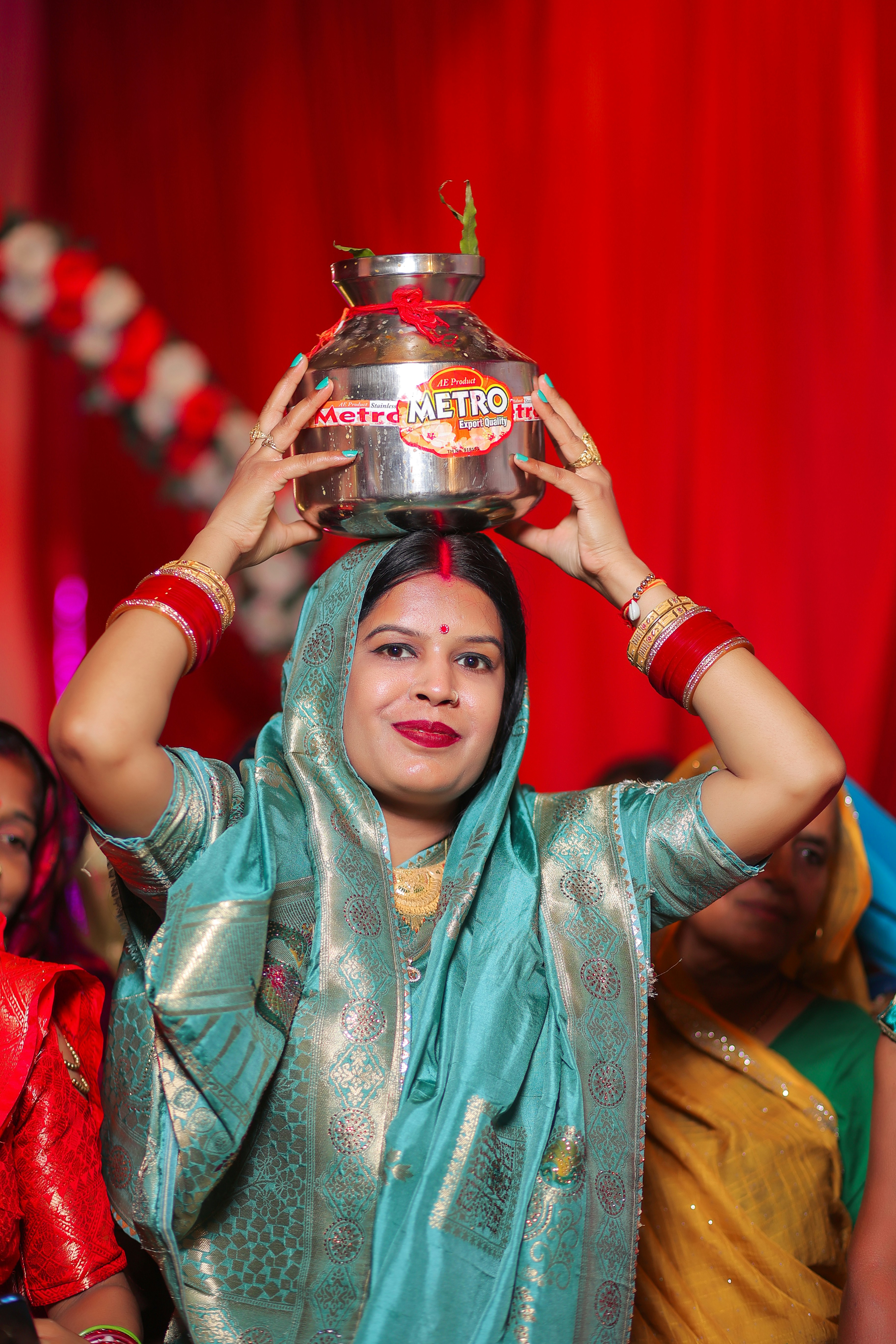 Teal Saree Balance: Ritual Pot Crowned by Crimson Drapes