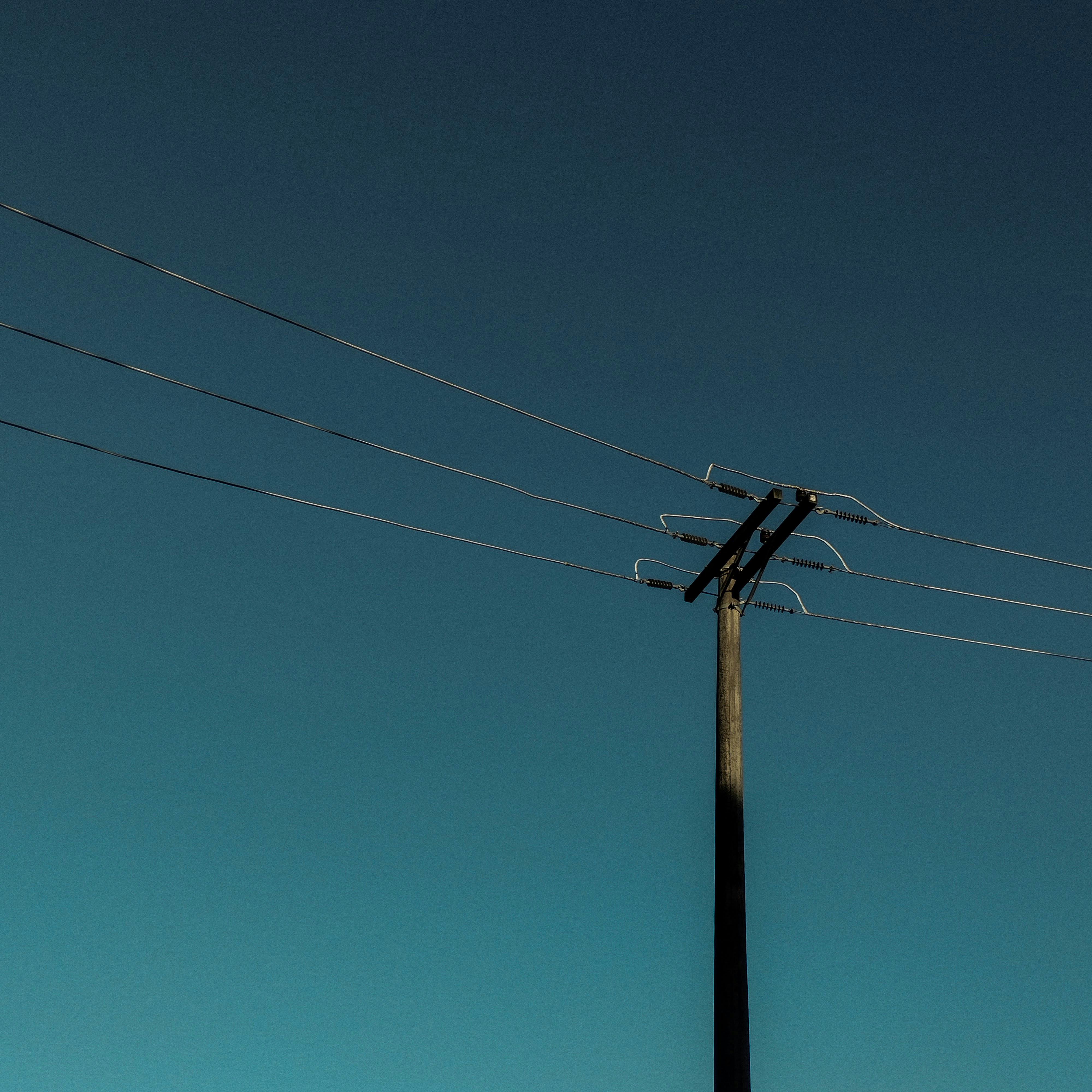 Telephone pole with wires against a clear blue sky