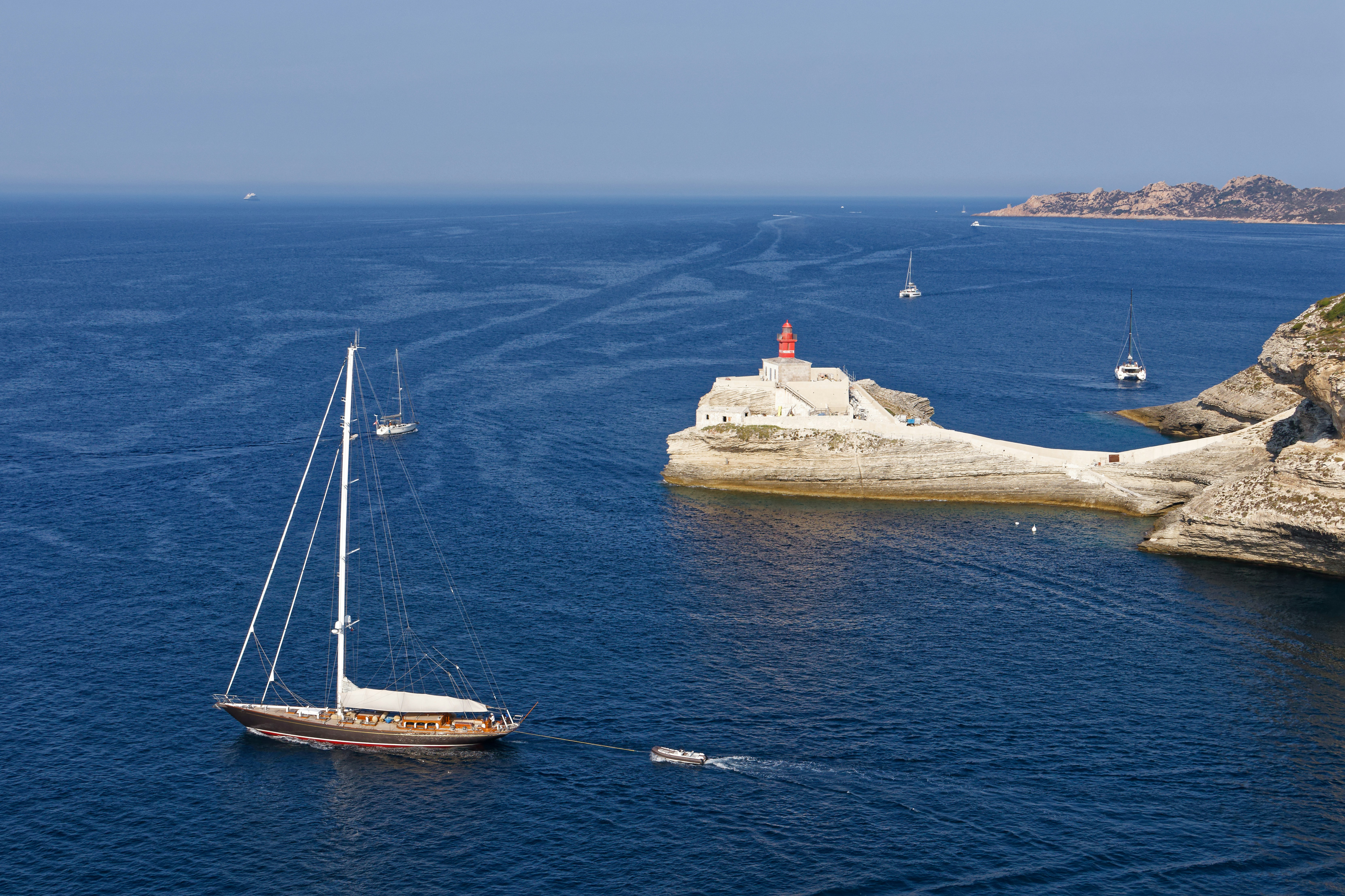 Red Beacon at the Rocky Cape: A Sloop in Calm Atlantic Waters