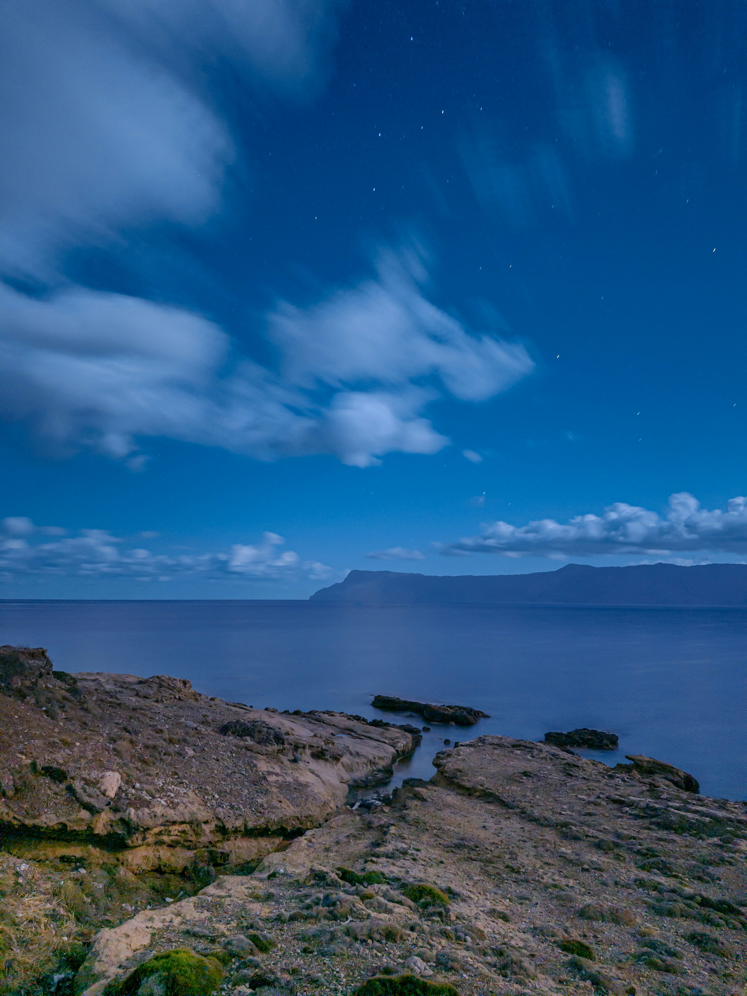 Rocky coastline under a starry night sky