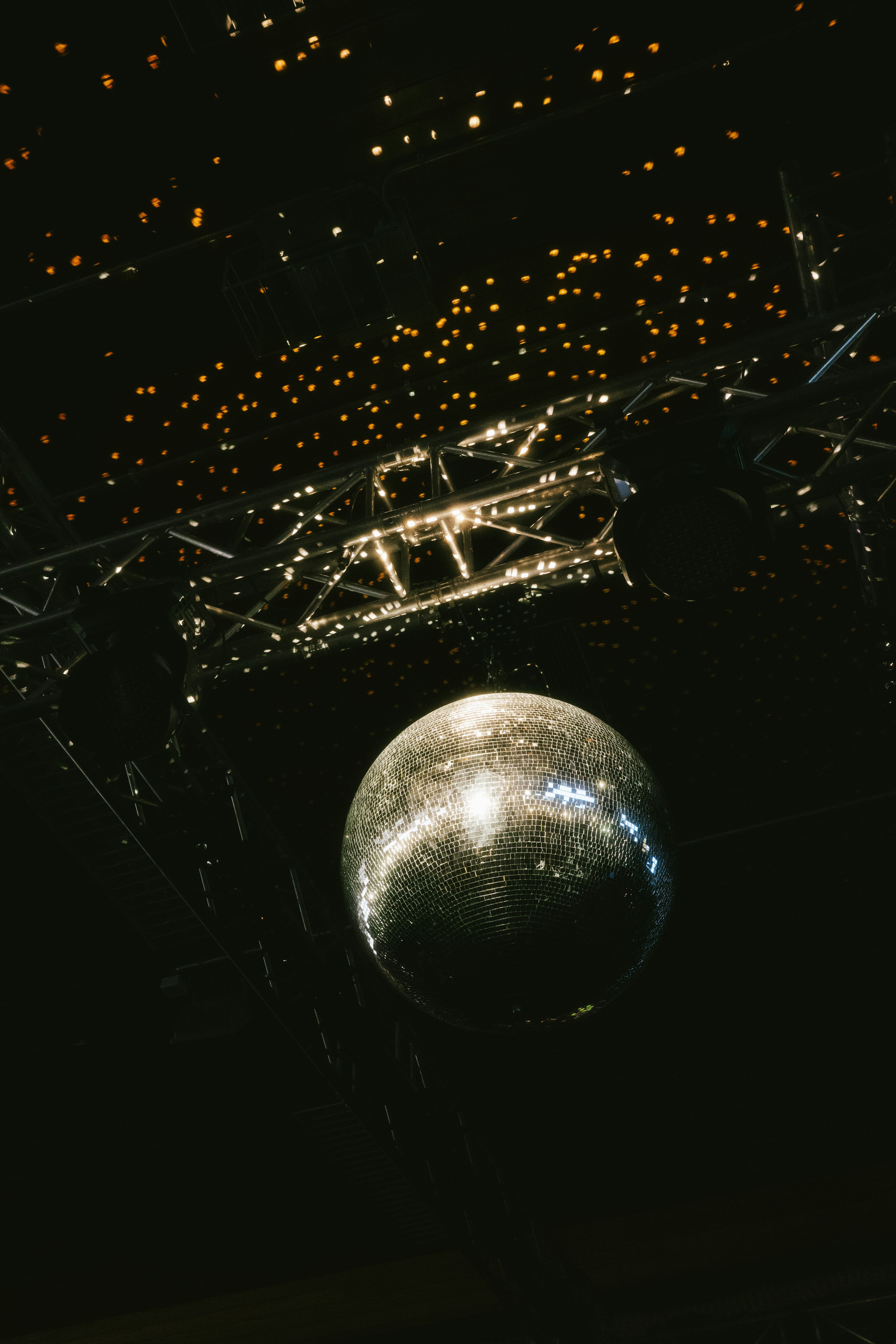disco | A disco ball hangs from a dark ceiling