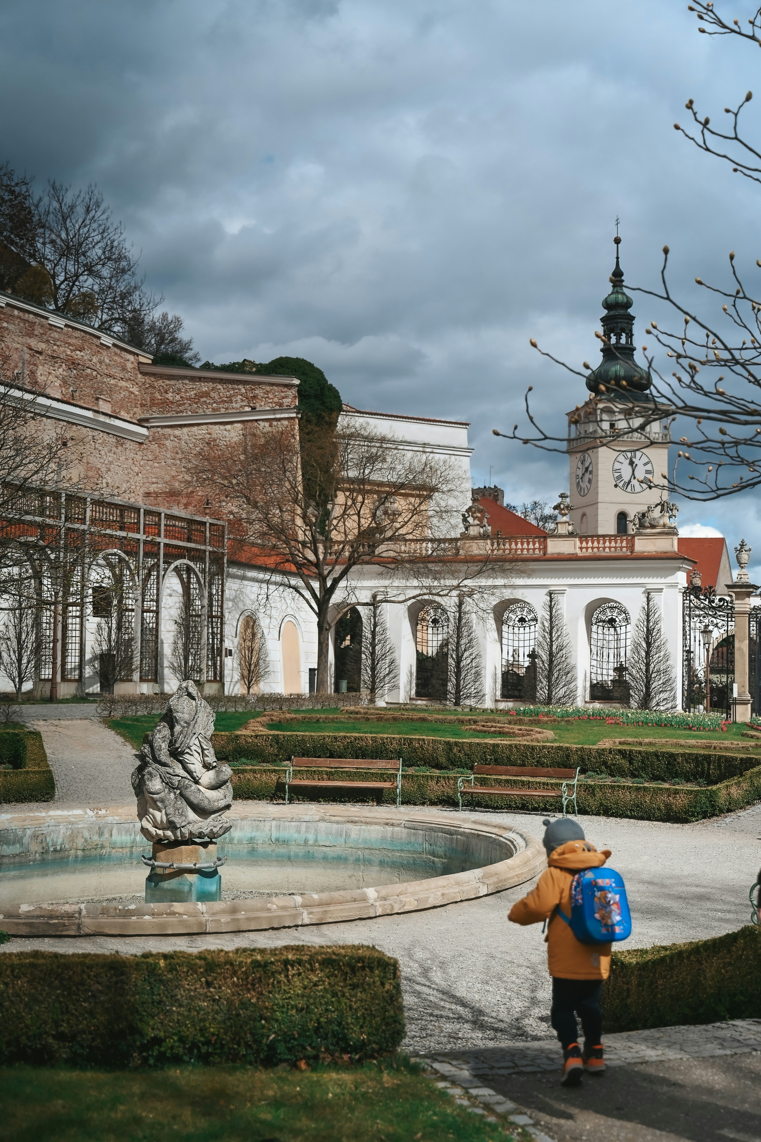 Orange Backpack, European Square: A Quiet Walk Toward the Clocktower