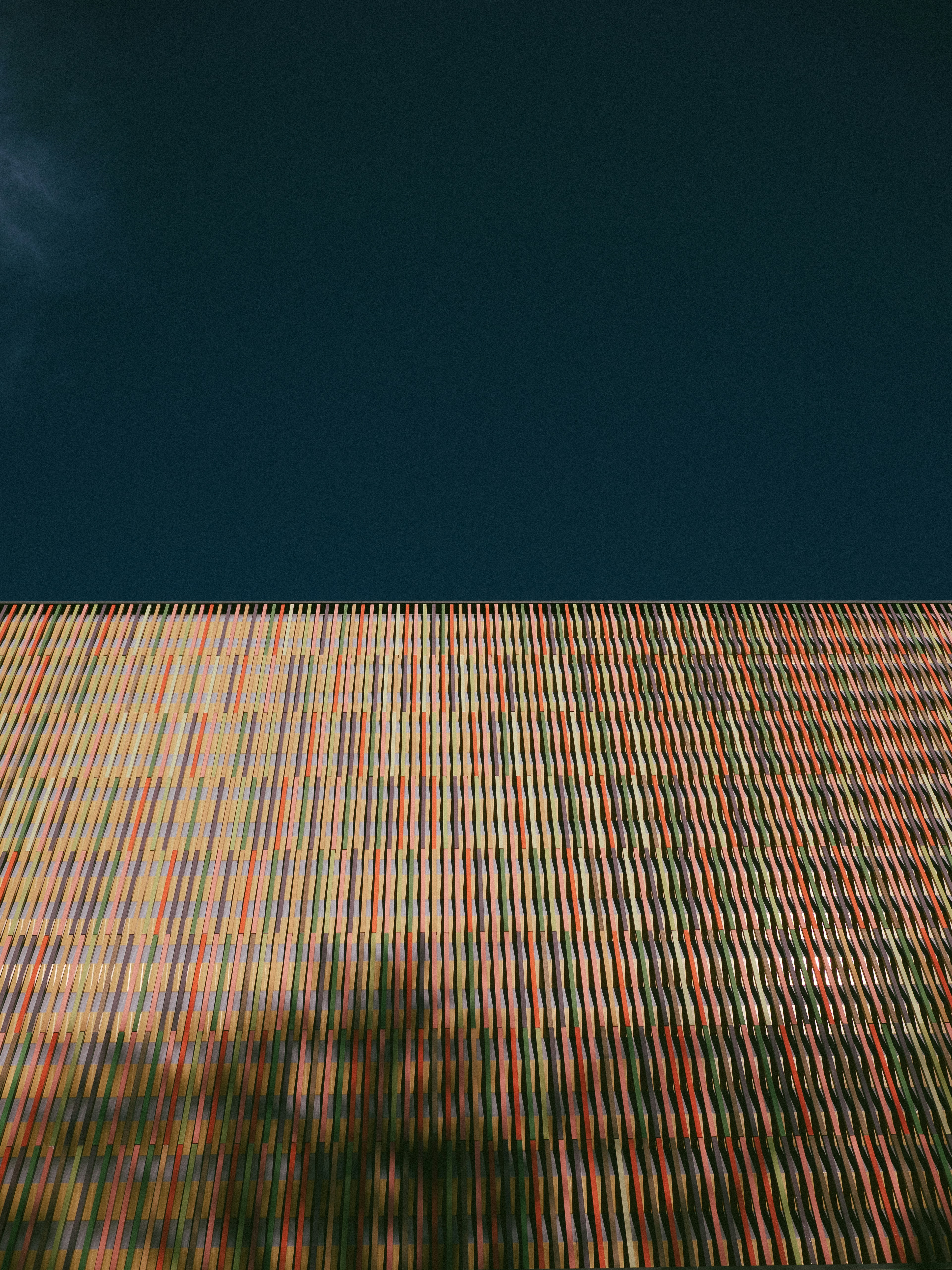 colour building | Abstract pattern of colorful vertical lines against dark sky