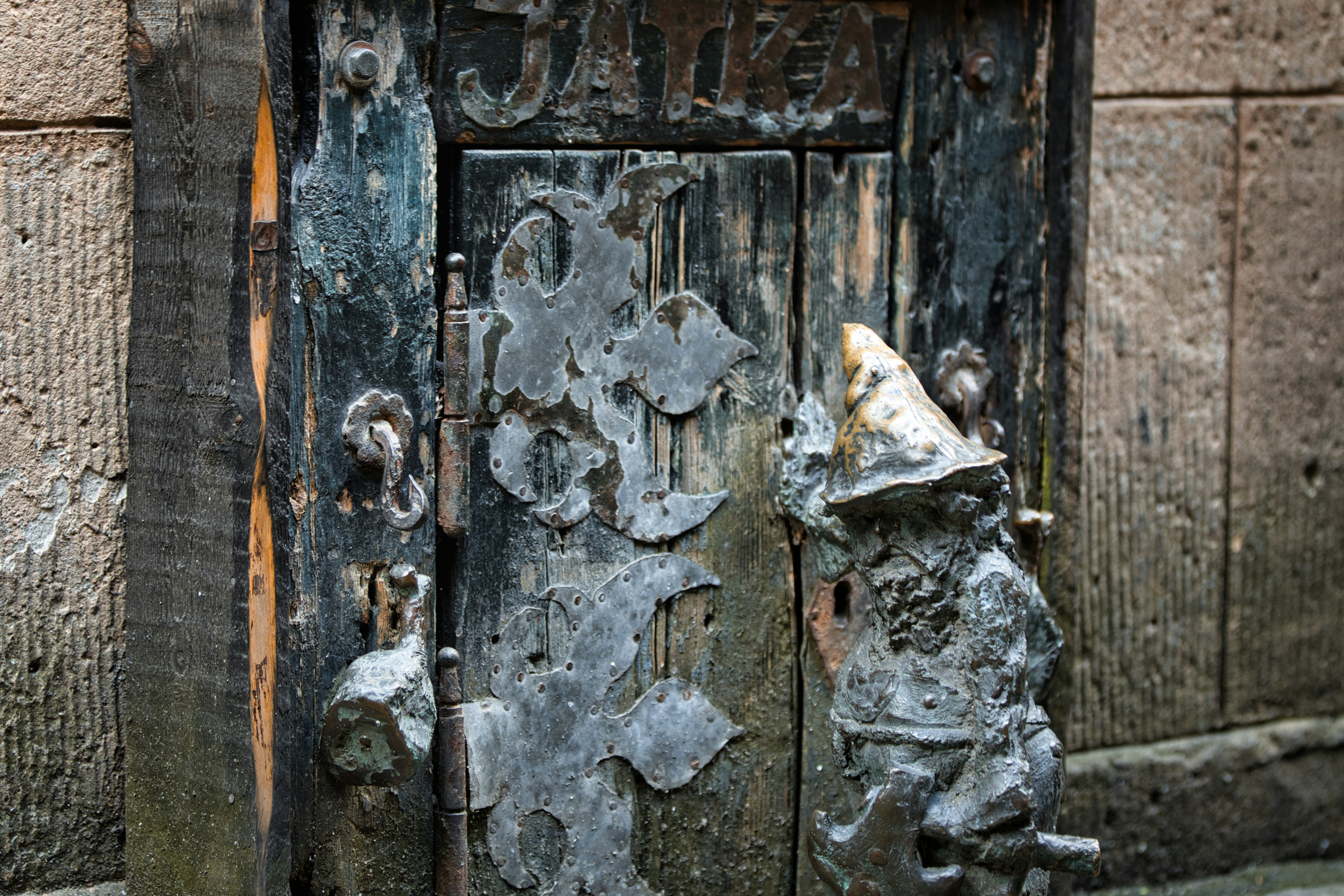 A small gnome statue by an ornate wooden door