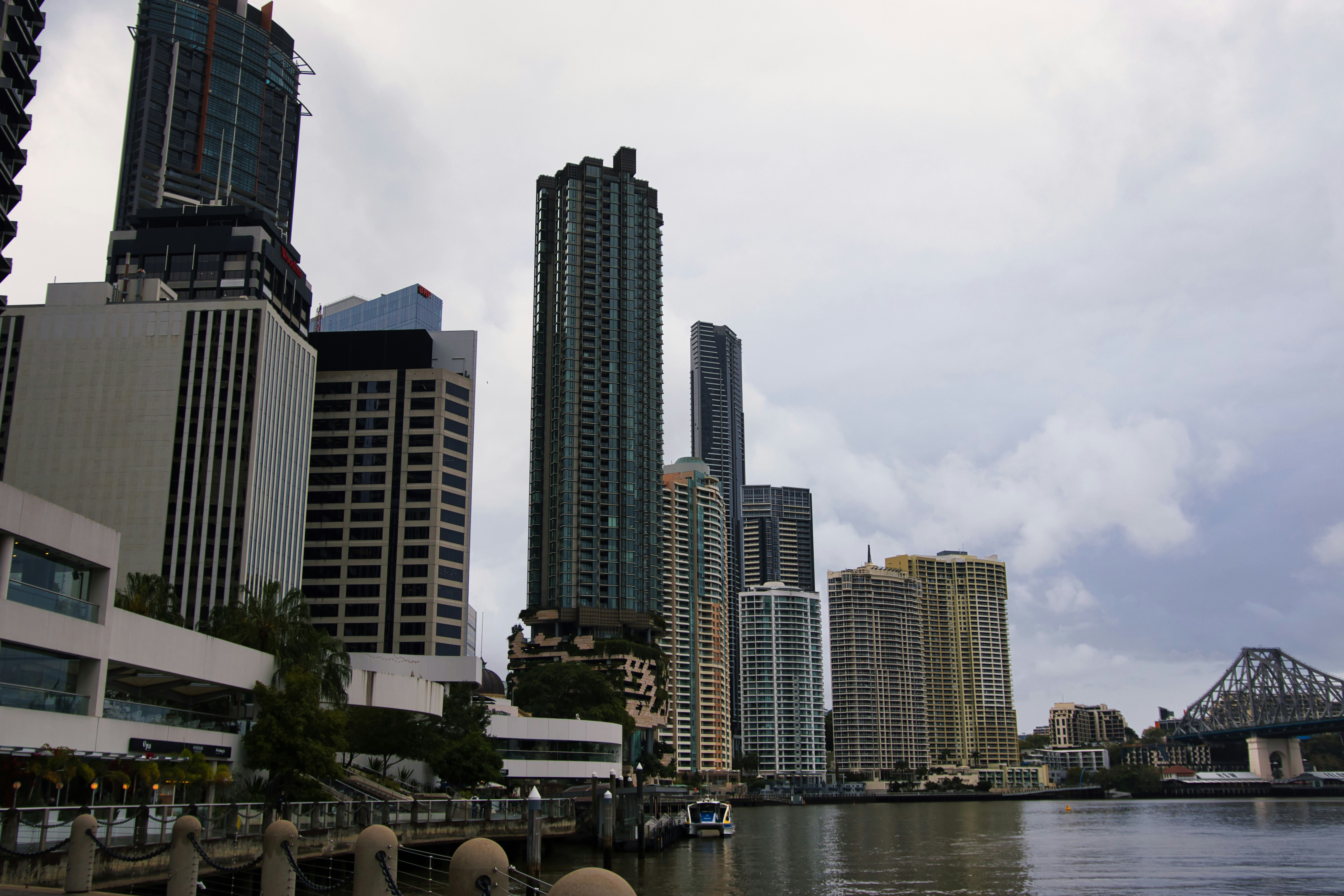 City skyline with tall buildings and a bridge.