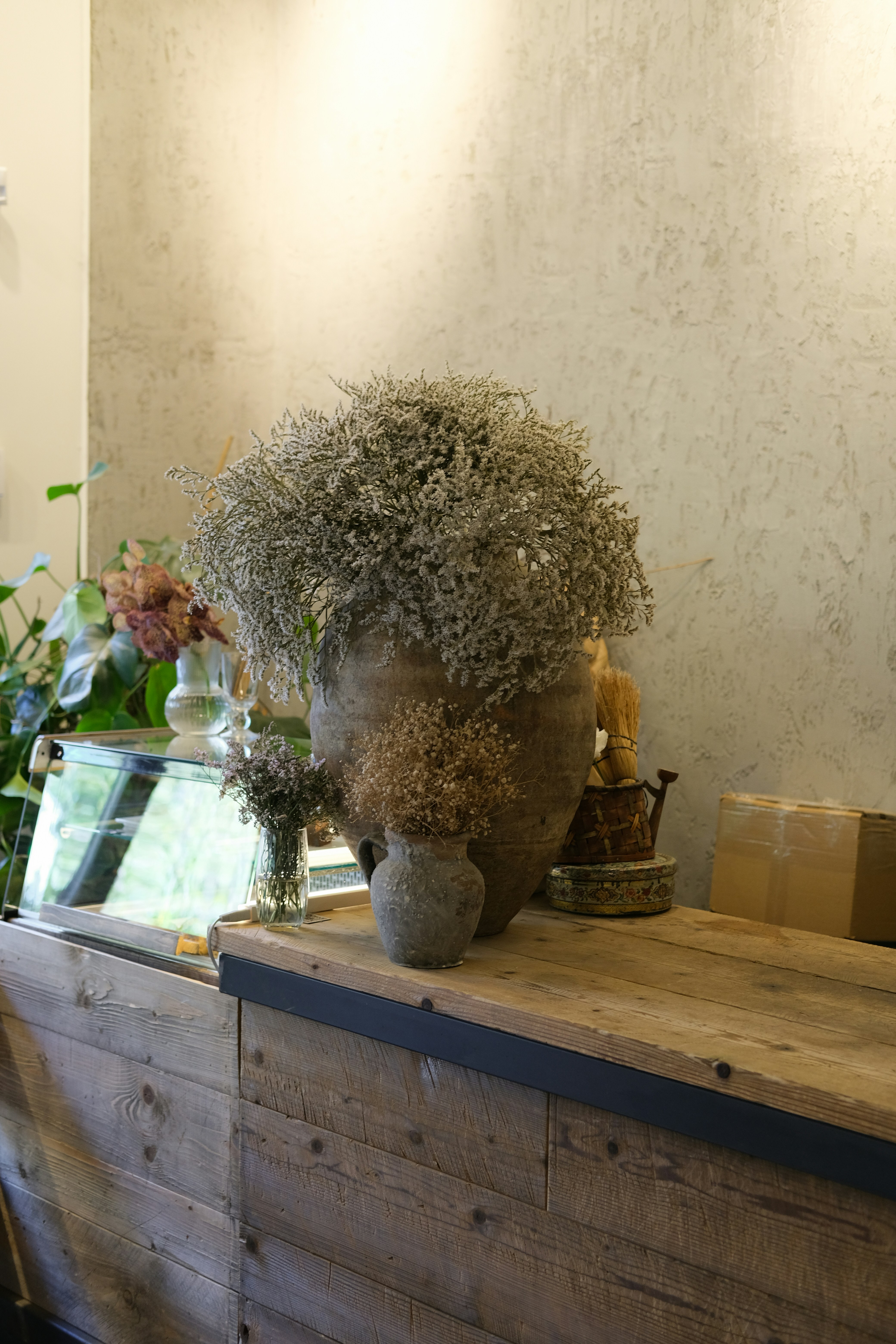 Dusty Botanicals in a Weathered Vase on a Rustic Counter