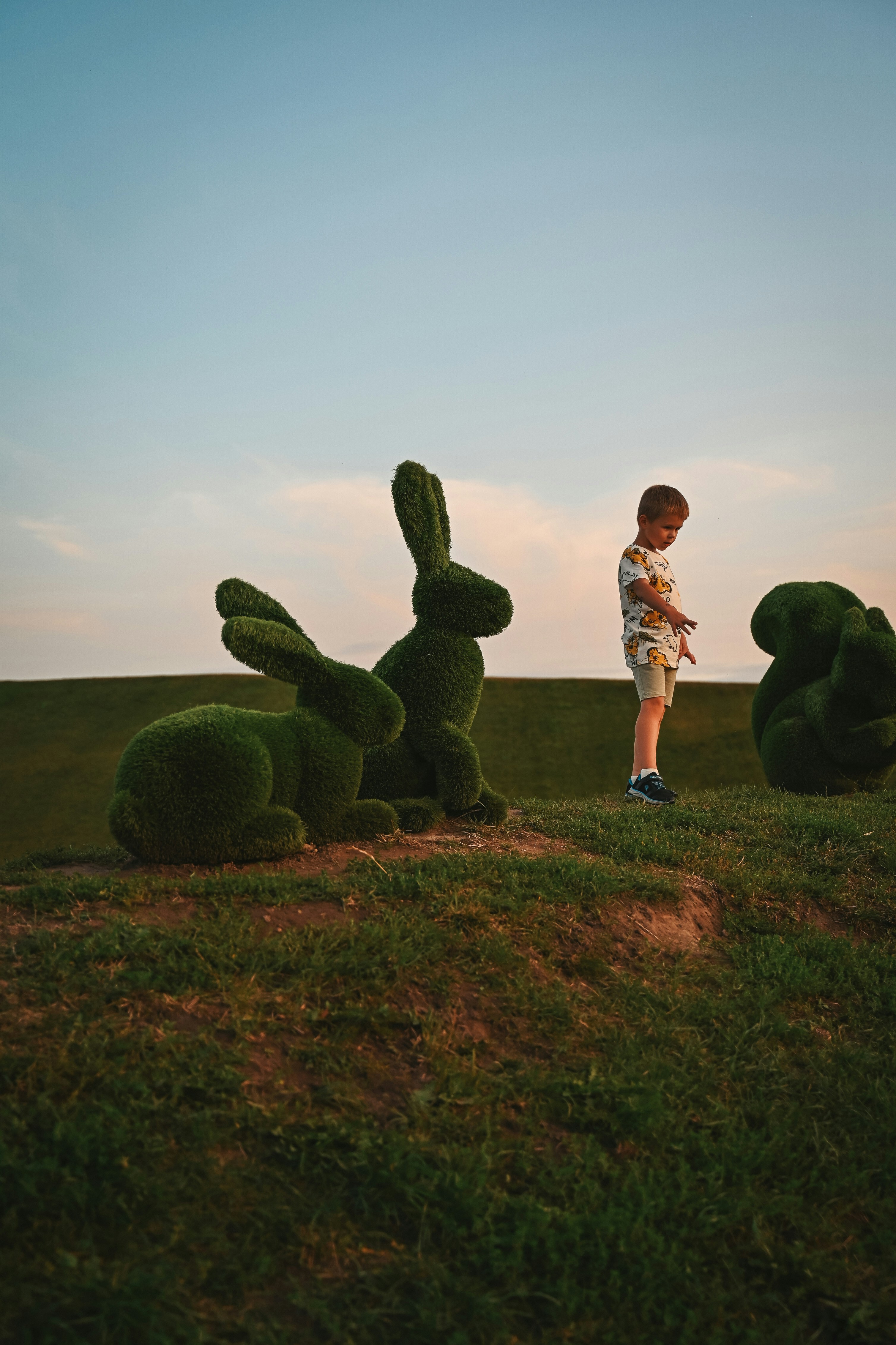 Whimsical Encounters: A Child's Delight Among Topiary Friends