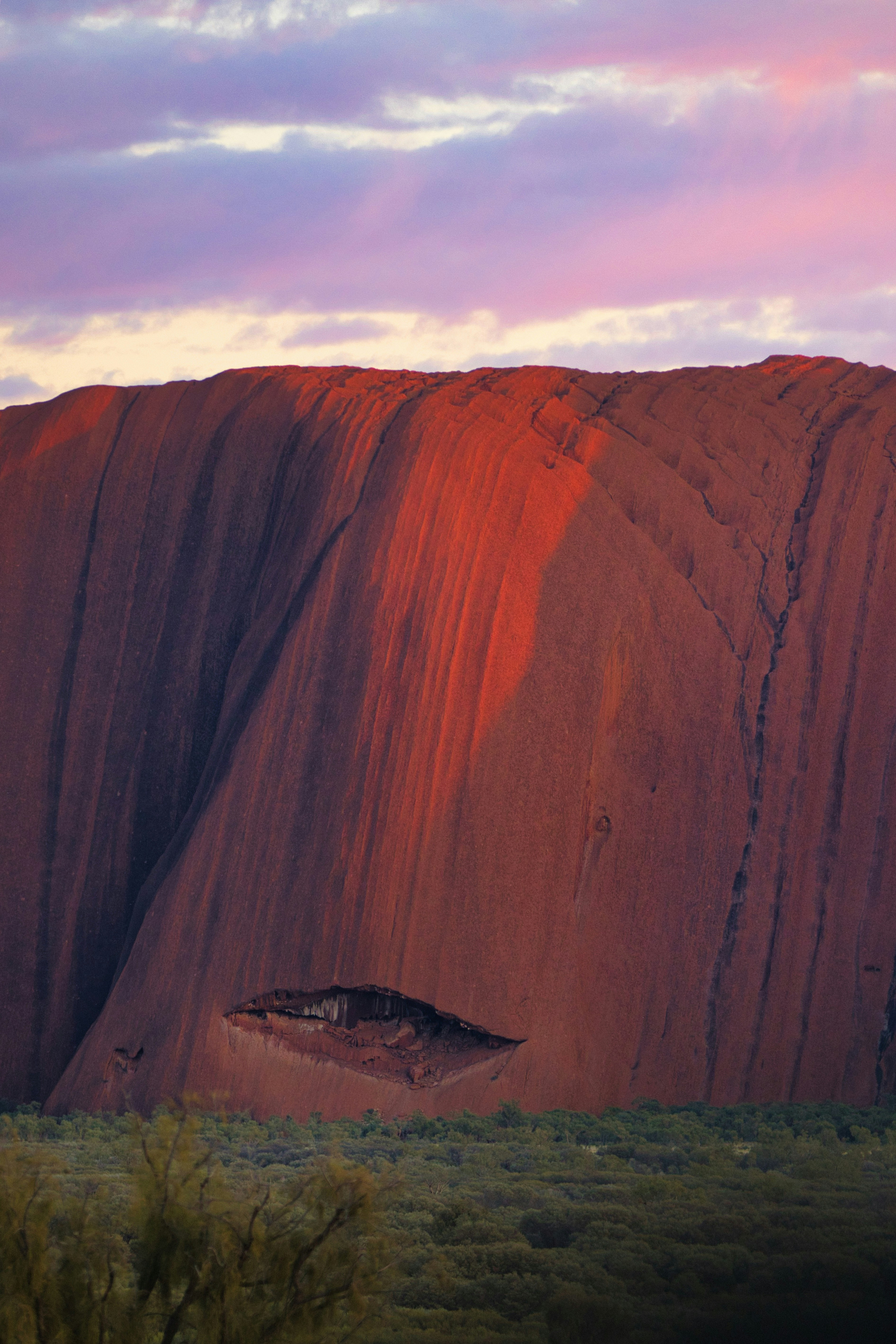 Dusk on the Crimson Monolith: Striated Rock Against a Pastel Sky