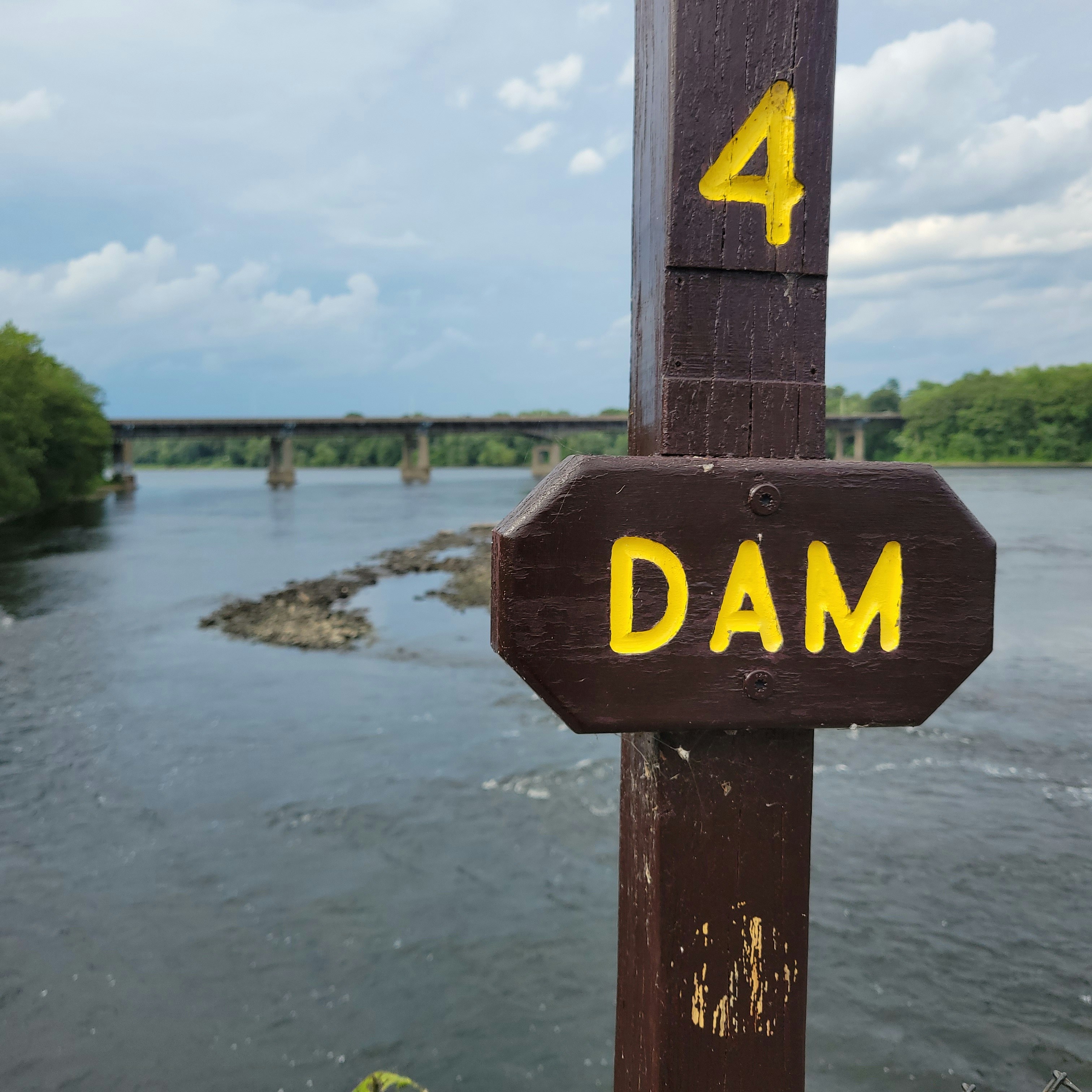 Wooden post with sign indicating dam number 4