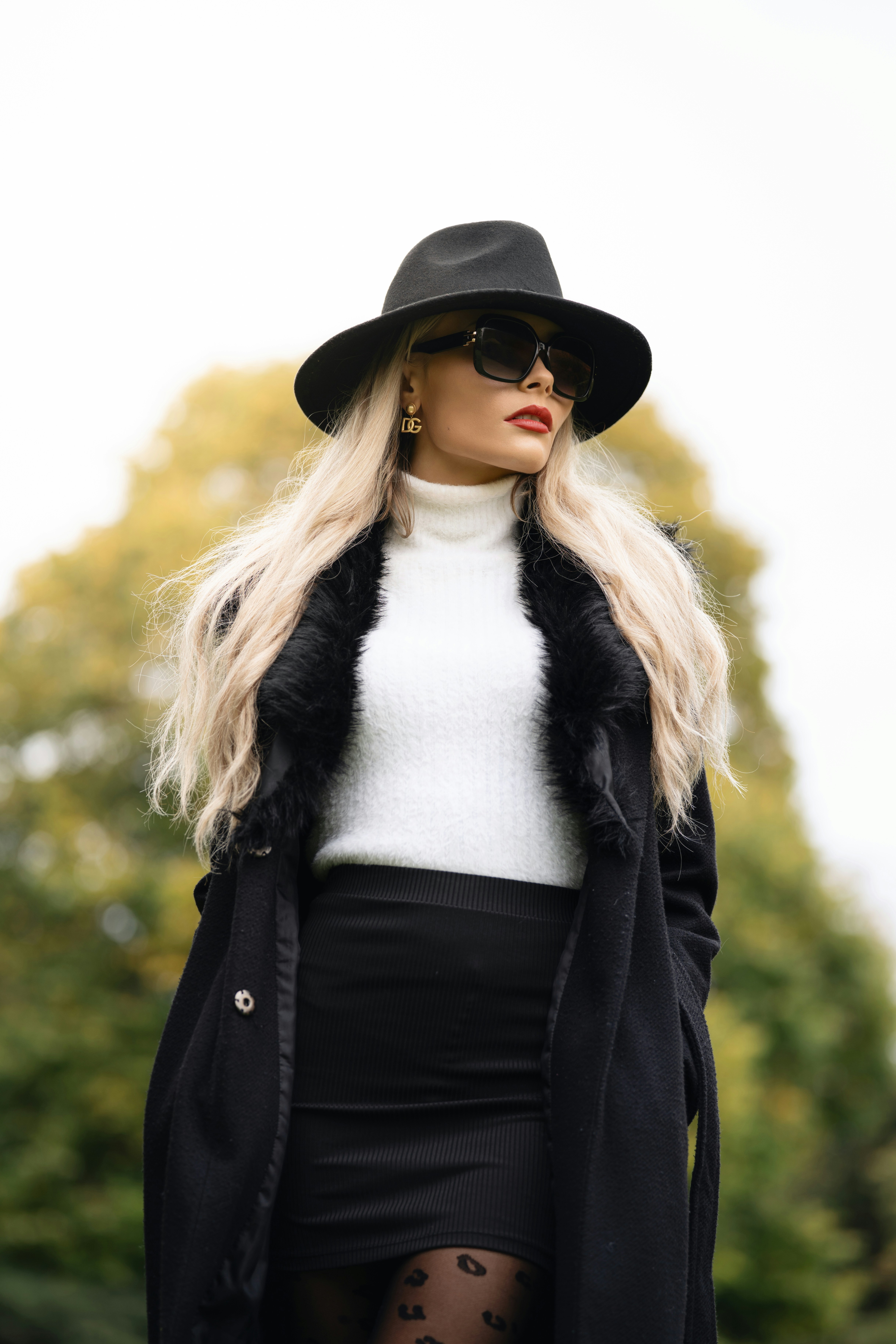 Stylish woman in hat and coat outdoors