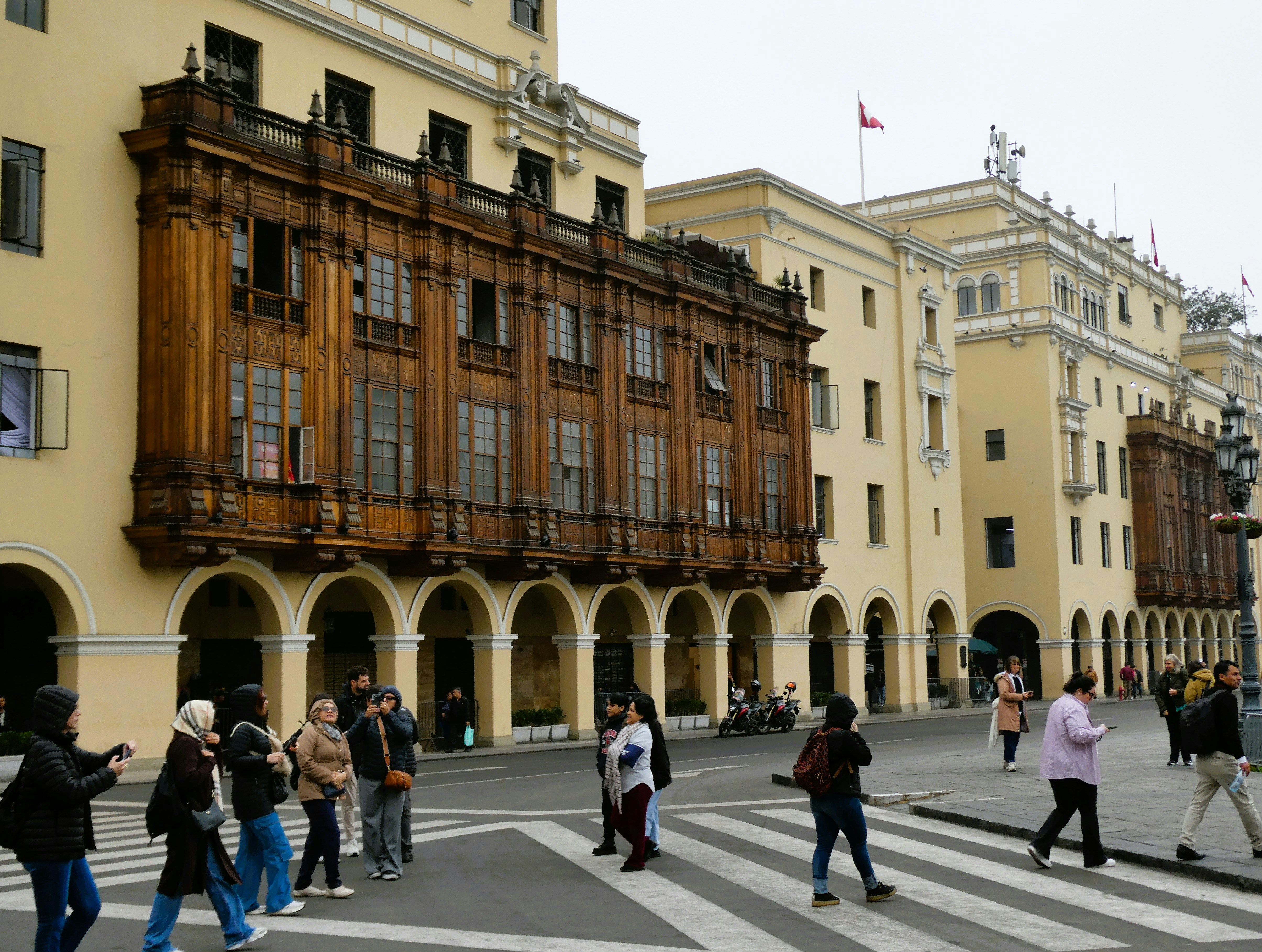 People crossing street in front of historic buildings