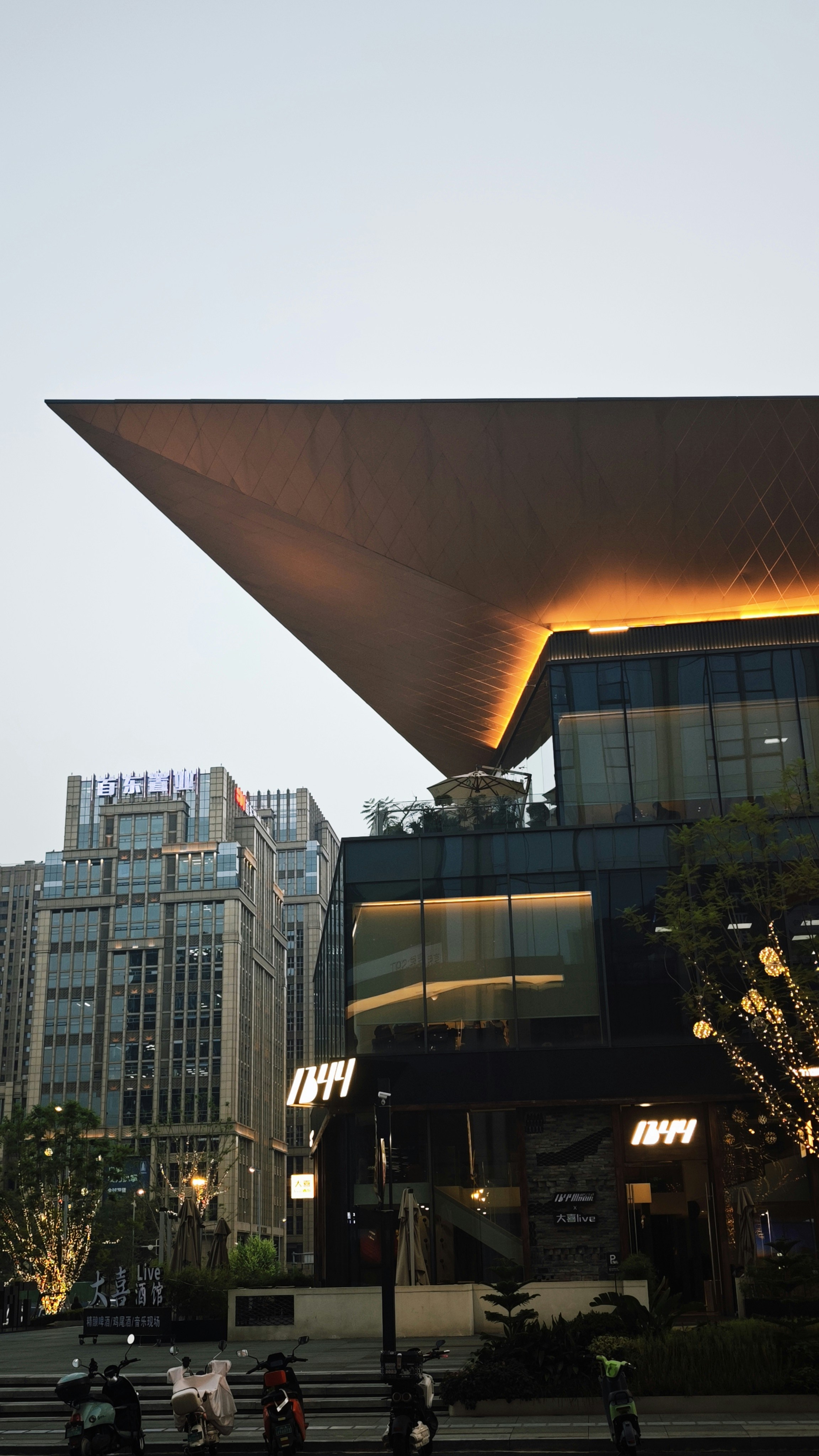 South town of Chengdu China, at the time of sunset. | Modern building with unique geometric roof design at dusk