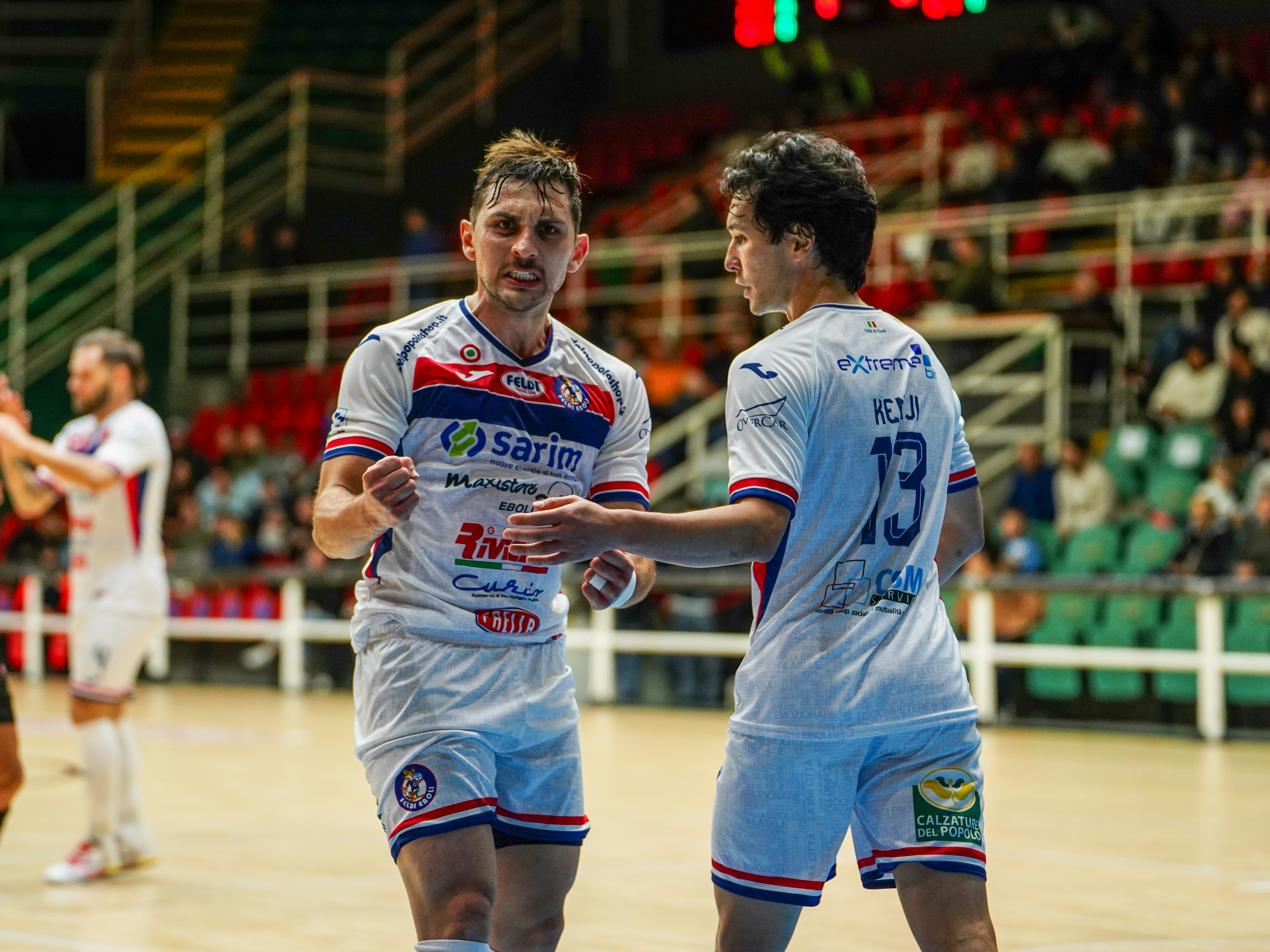 Two soccer players celebrating on the court.