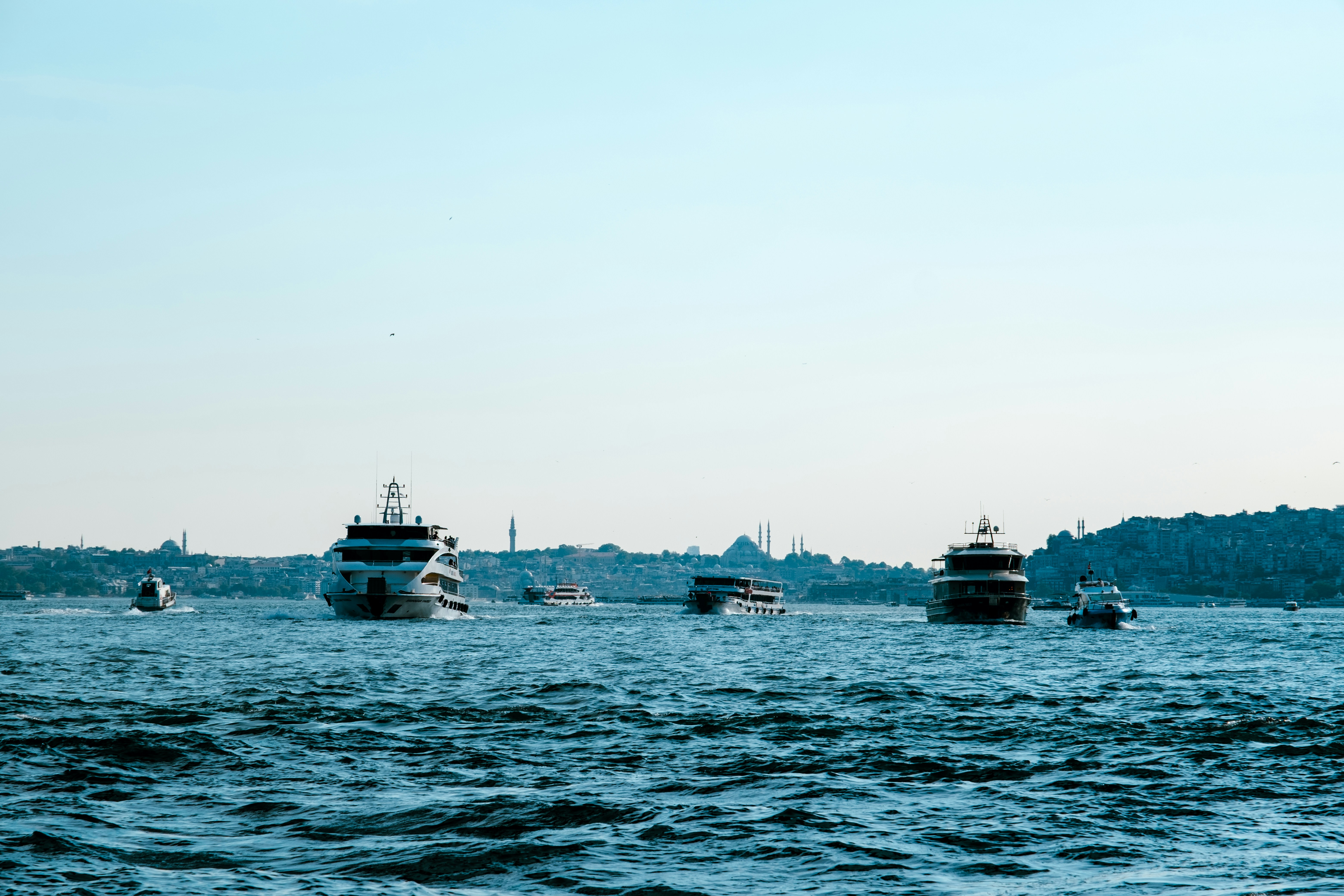 Several boats sail on a calm blue sea.