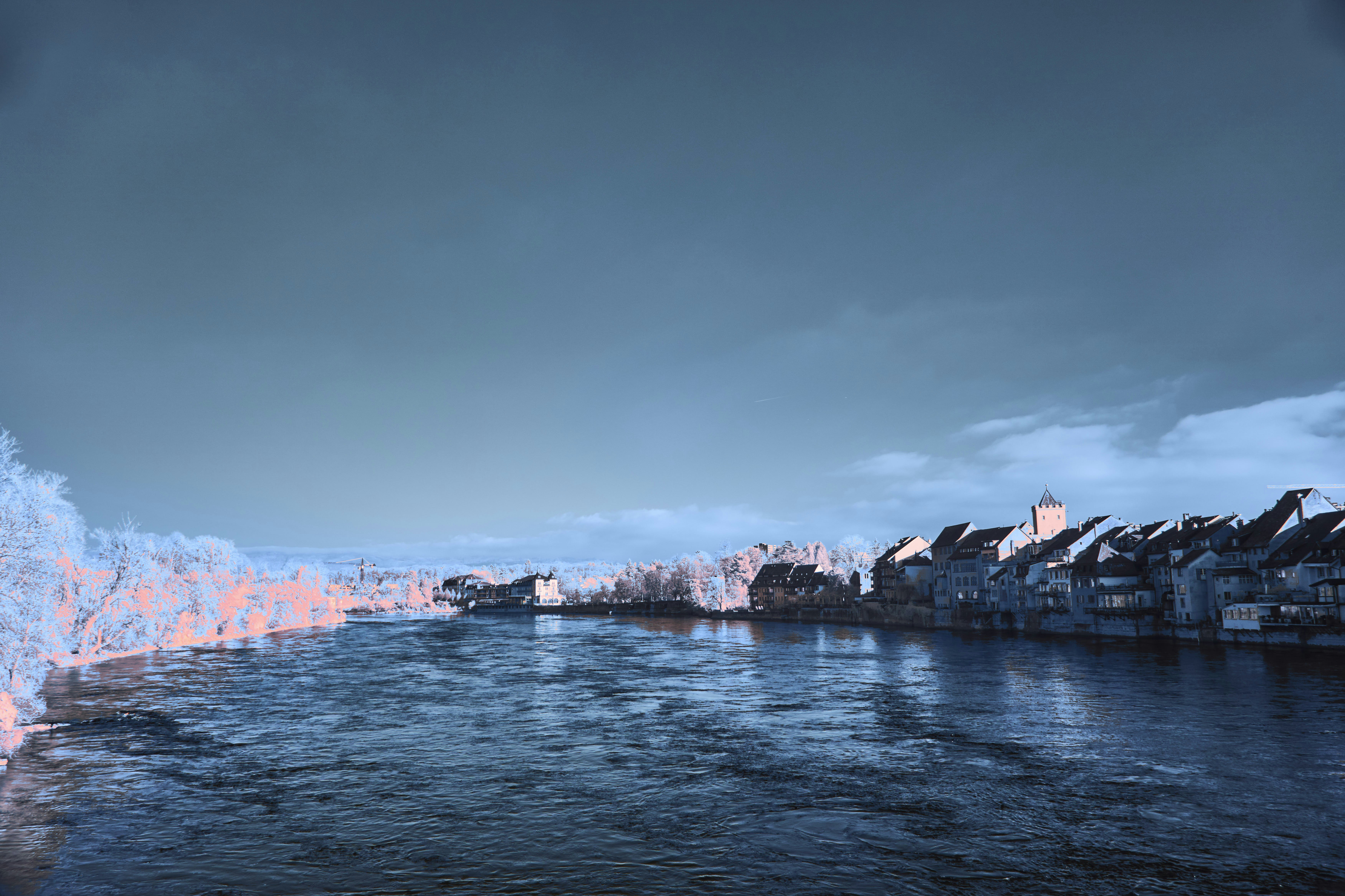 River flowing past buildings with trees on bank