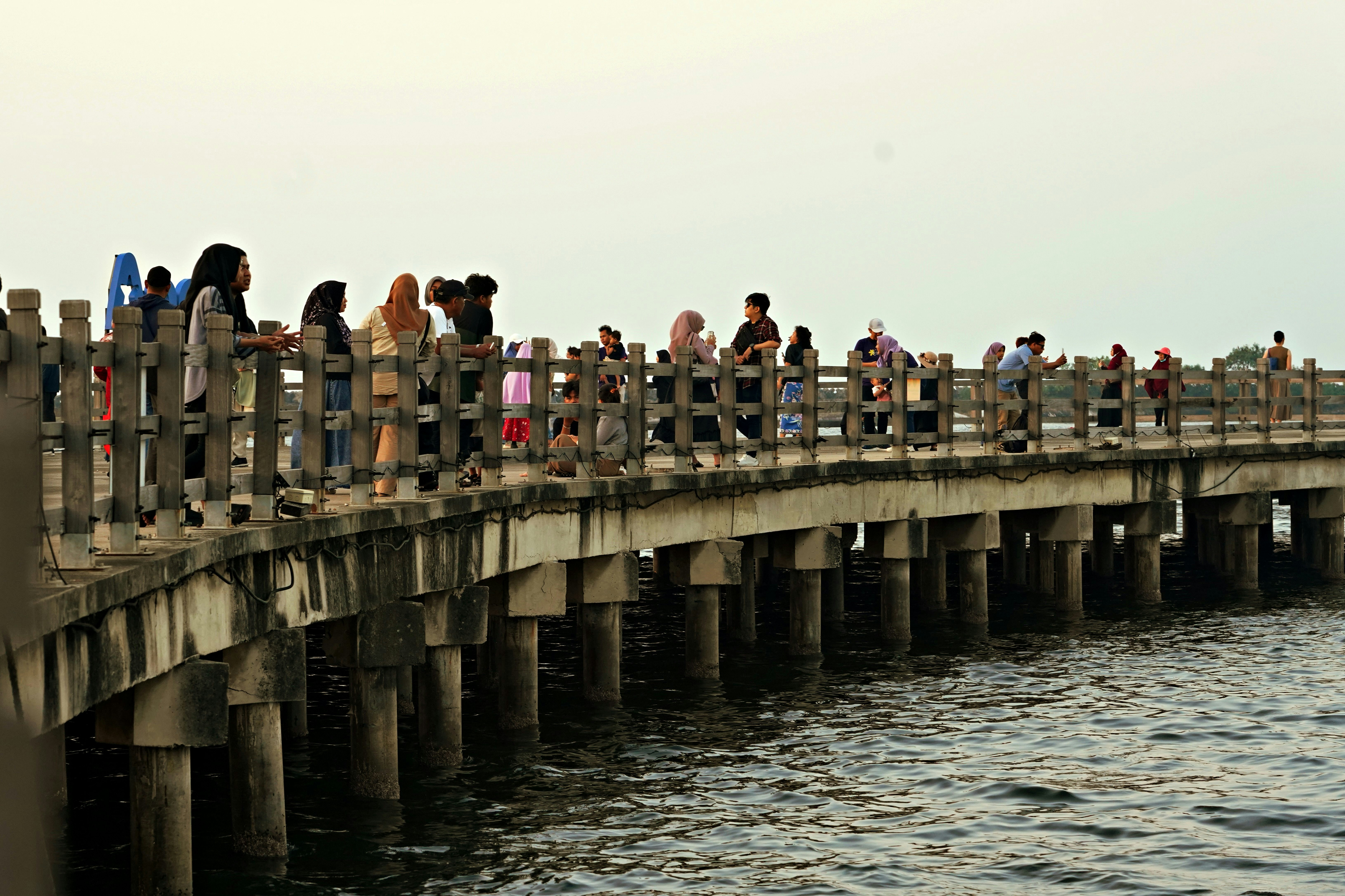People walking on a concrete pier over water photo – Free Bridge Image ...