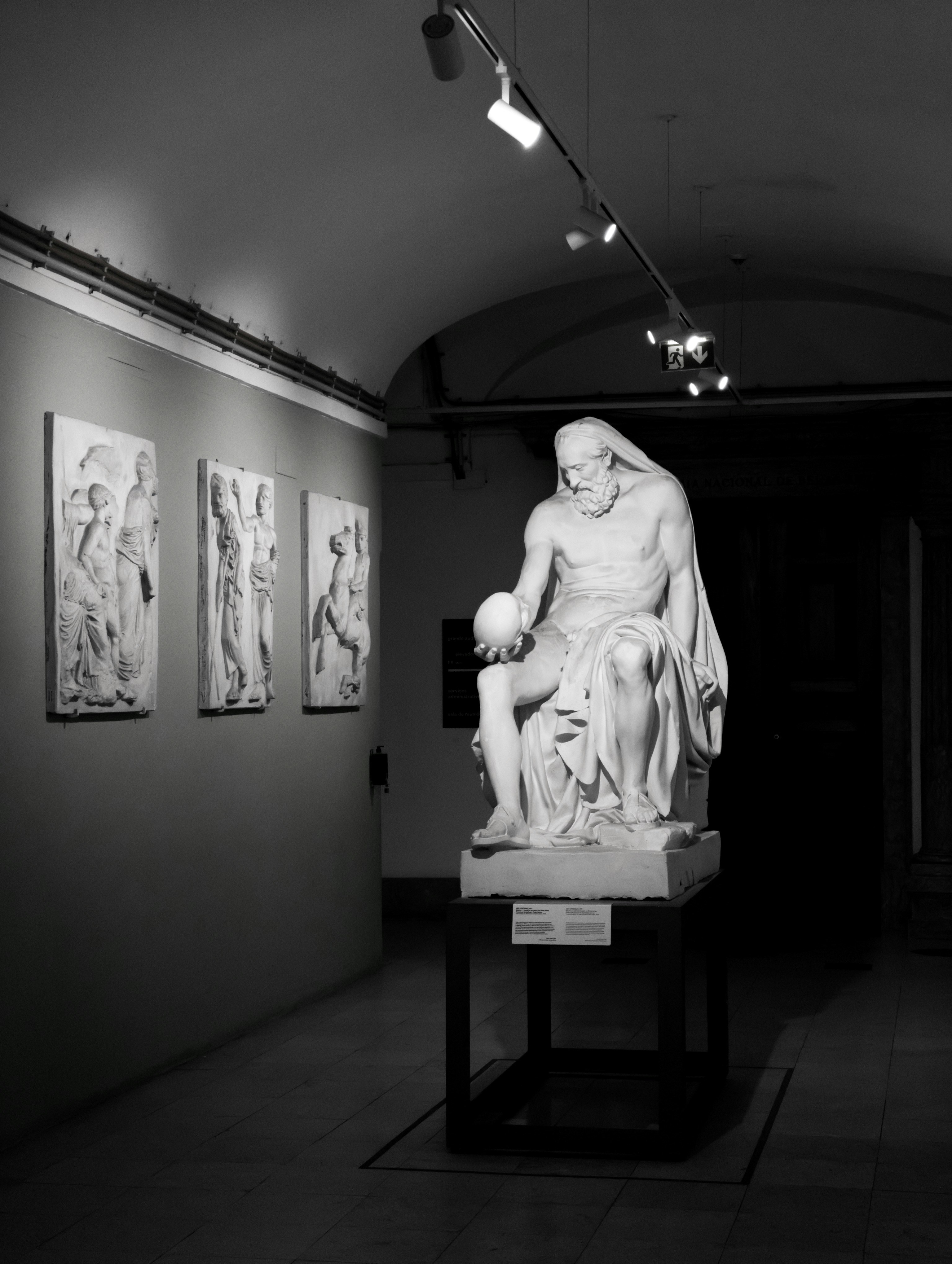 Faculdade de Belas-Artes da Universidade de Lisboa | A sculpture of a seated man holding a globe.