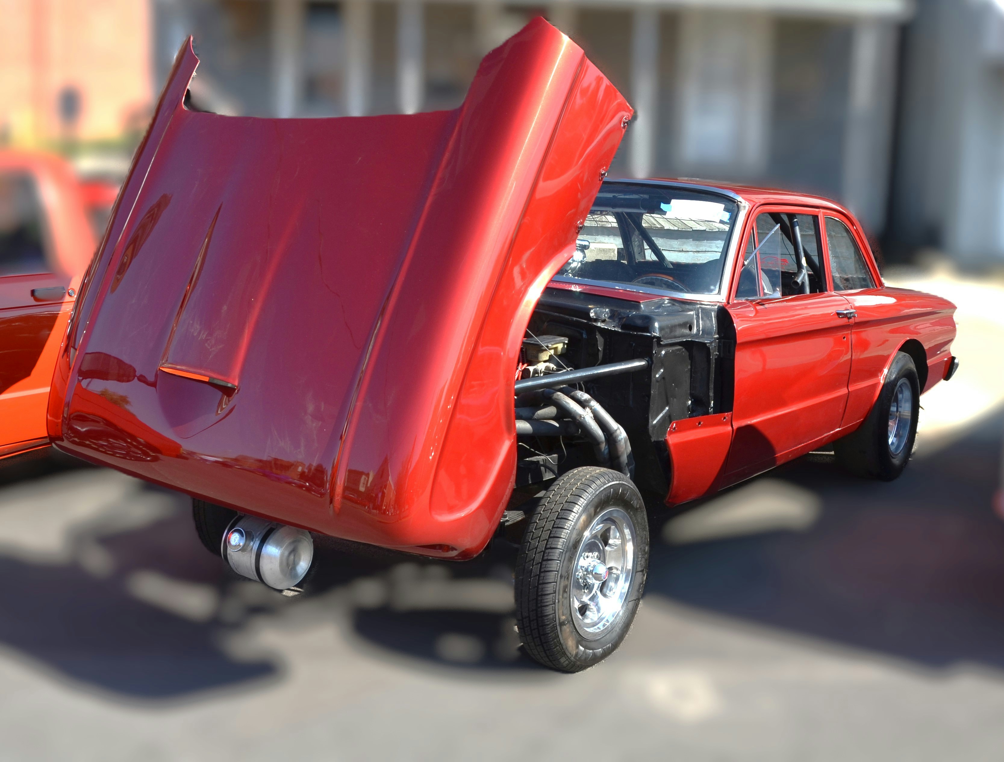 Red Classic with Propped Hood: A Glimpse Under the Chrome