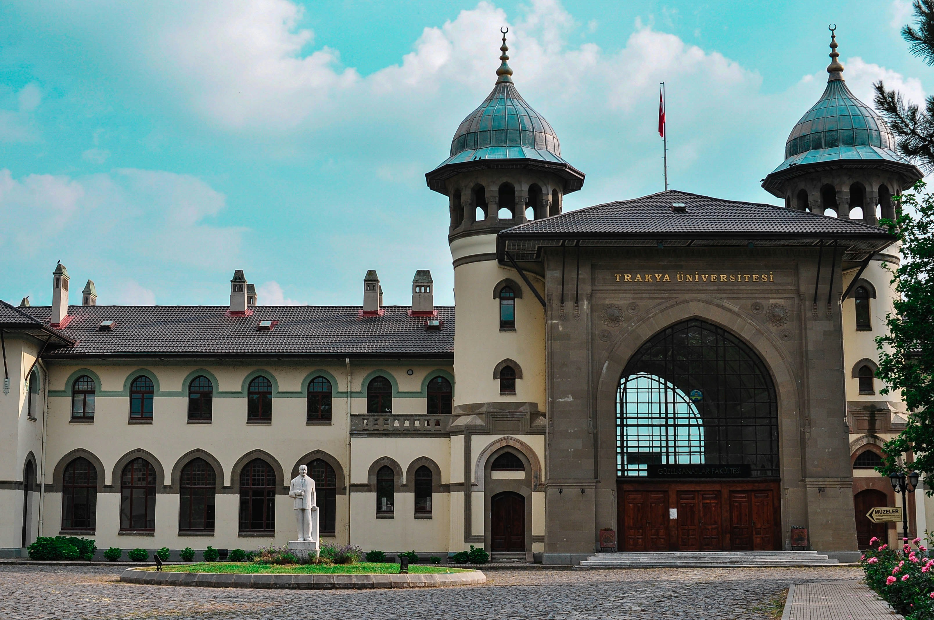 Grand arched entrance to a historic building with towers.