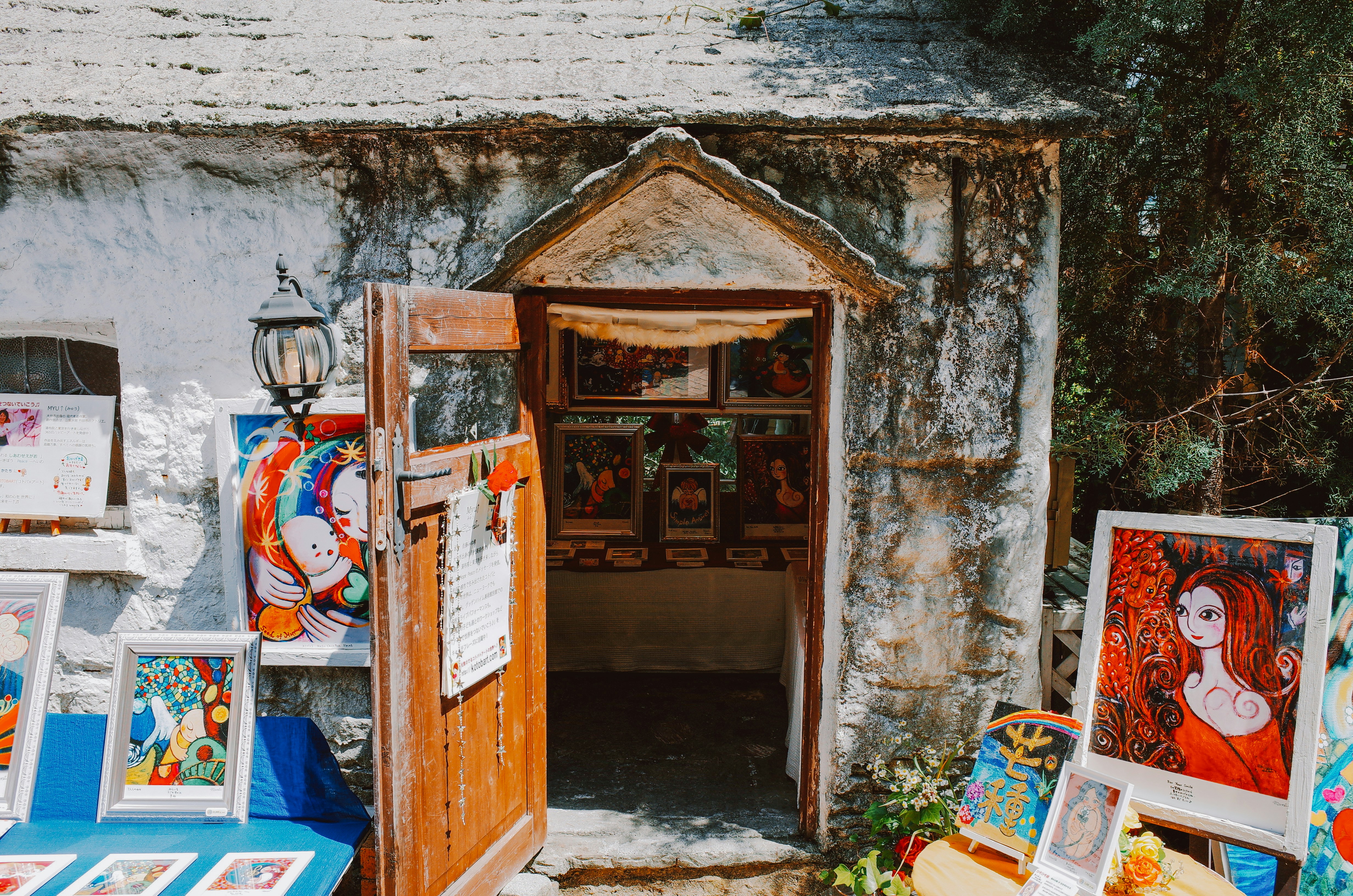 Art displayed outside a rustic stone building