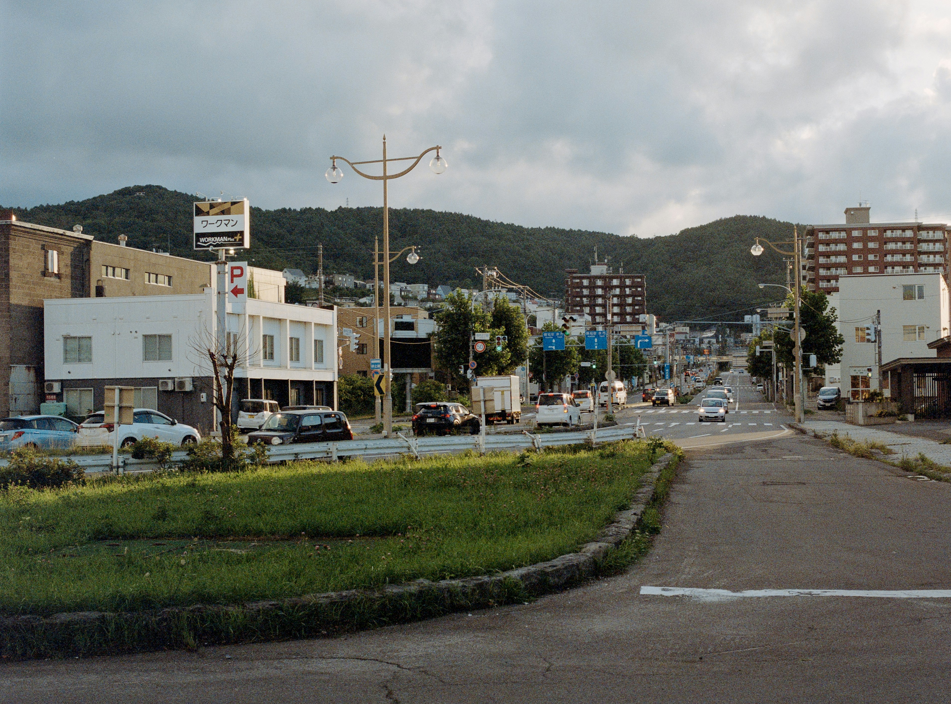 🎞️ Kodak Professional Portra 800｜🧪 Fuji Hunt C-41｜🖨️ EOS R6 + RF 100mm f/2.8L Macro｜📷 Mamiya 645 Pro + Mamiya-Sekor 80mm 1:1.9 | Street view of a town with buildings and hills.