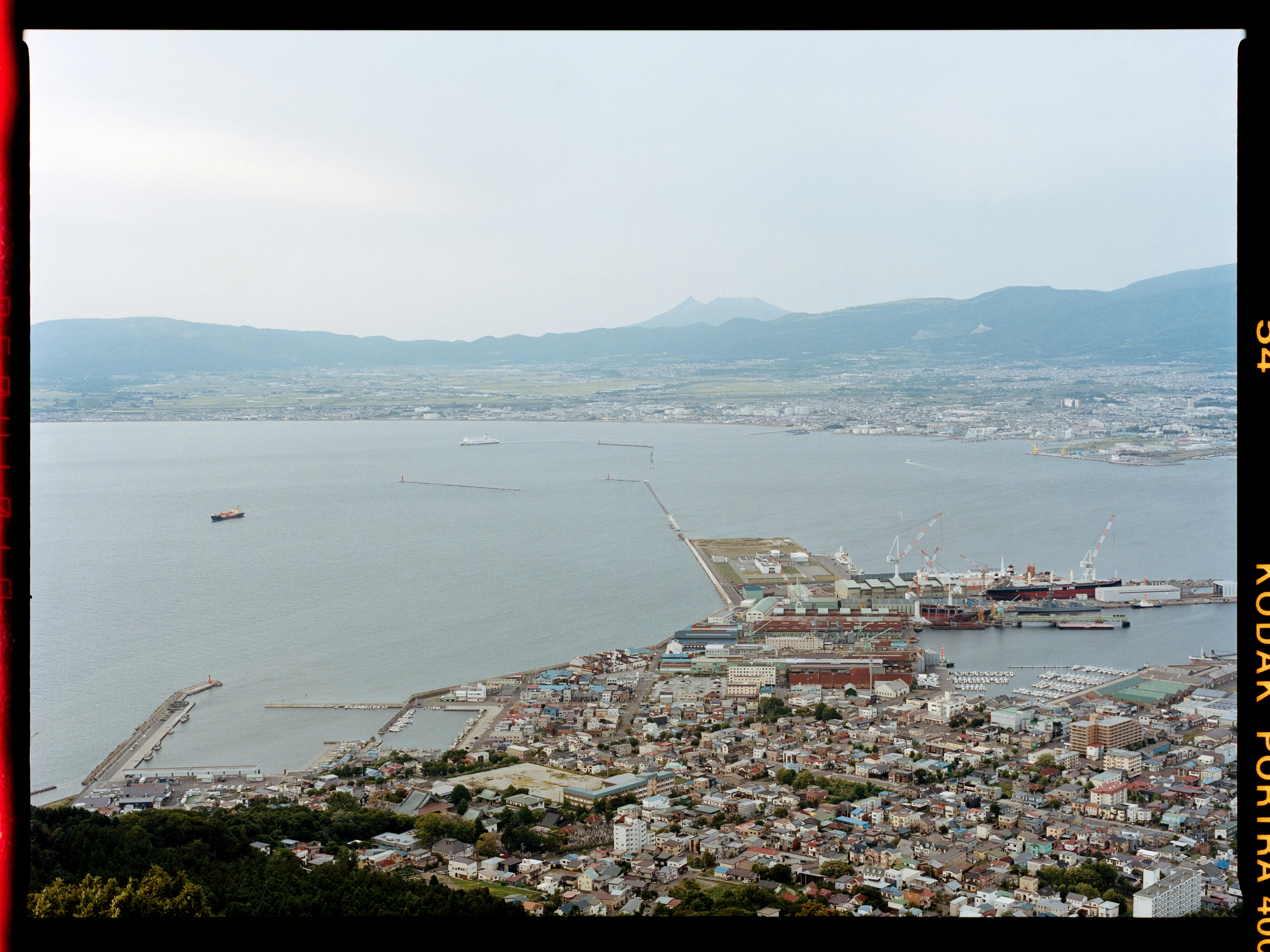 🎞️ Kodak Professional Portra 400｜🧪 Fuji Hunt C-41｜🖨️ EOS R6 + RF 100mm f/2.8L Macro｜📷 Mamiya 645 Pro + Mamiya-Sekor 80mm 1:1.9 | Coastal city with a large harbor and bay.