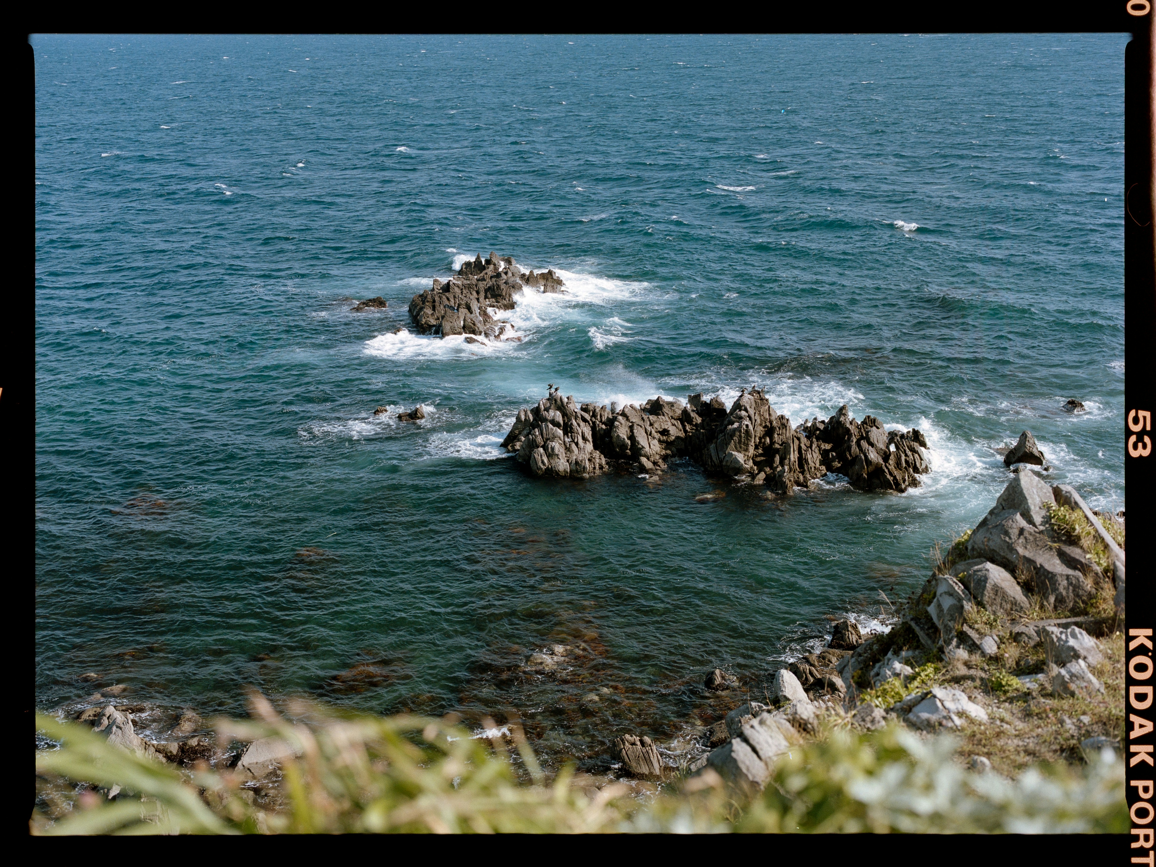 🎞️ Kodak Professional Portra 160｜🧪 Fuji Hunt C-41｜🖨️ EOS R6 + RF 100mm f/2.8L Macro｜📷 Mamiya 645 Pro + Mamiya-Sekor 80mm 1:1.9 | Waves crashing on rocky outcrops in the ocean.