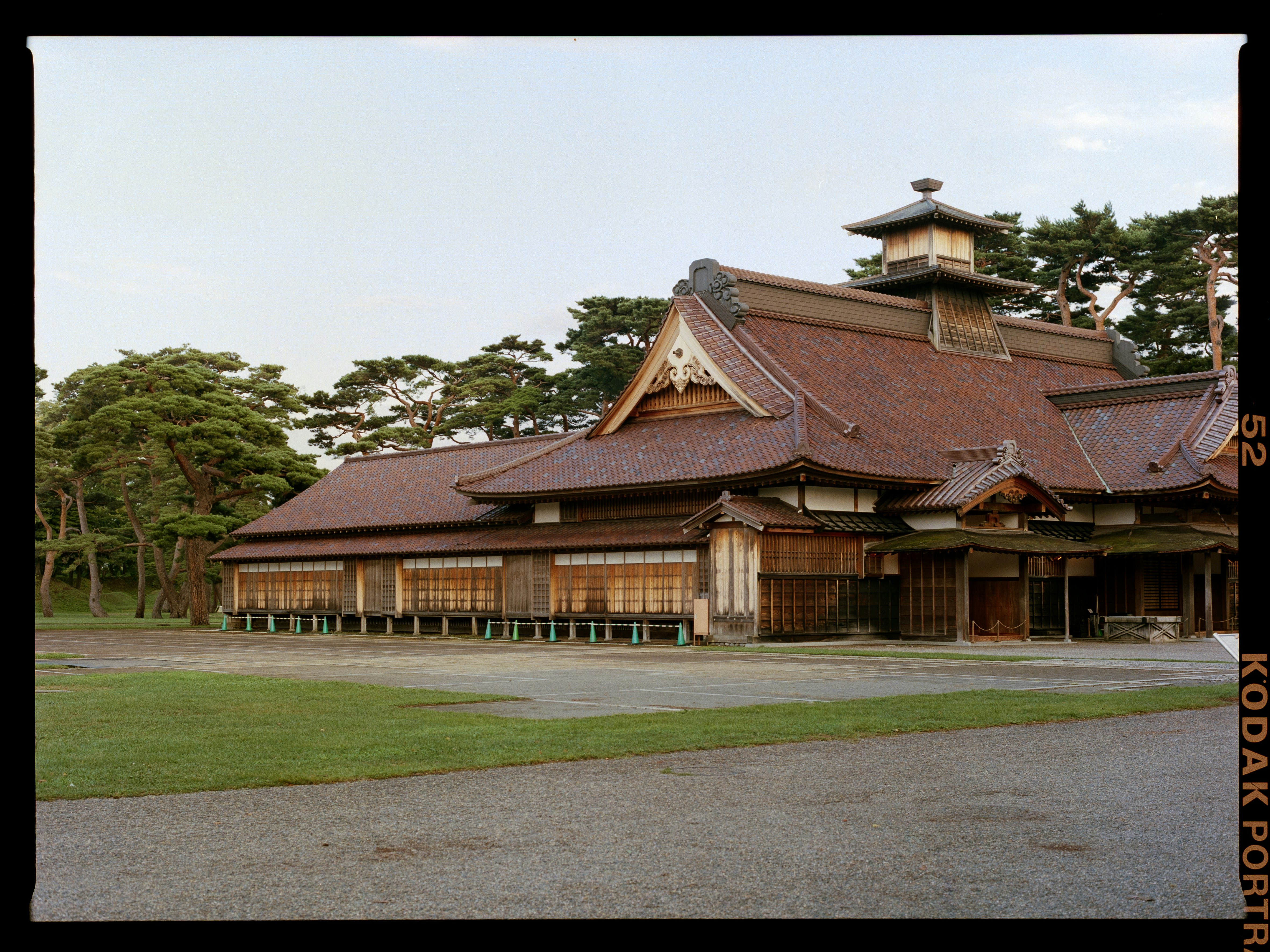 🎞️ Kodak Professional Portra 160｜🧪 Fuji Hunt C-41｜🖨️ EOS R6 + RF 100mm f/2.8L Macro｜📷 Mamiya 645 Pro + Mamiya-Sekor 80mm 1:1.9 | Traditional japanese building with tiled roof and trees.