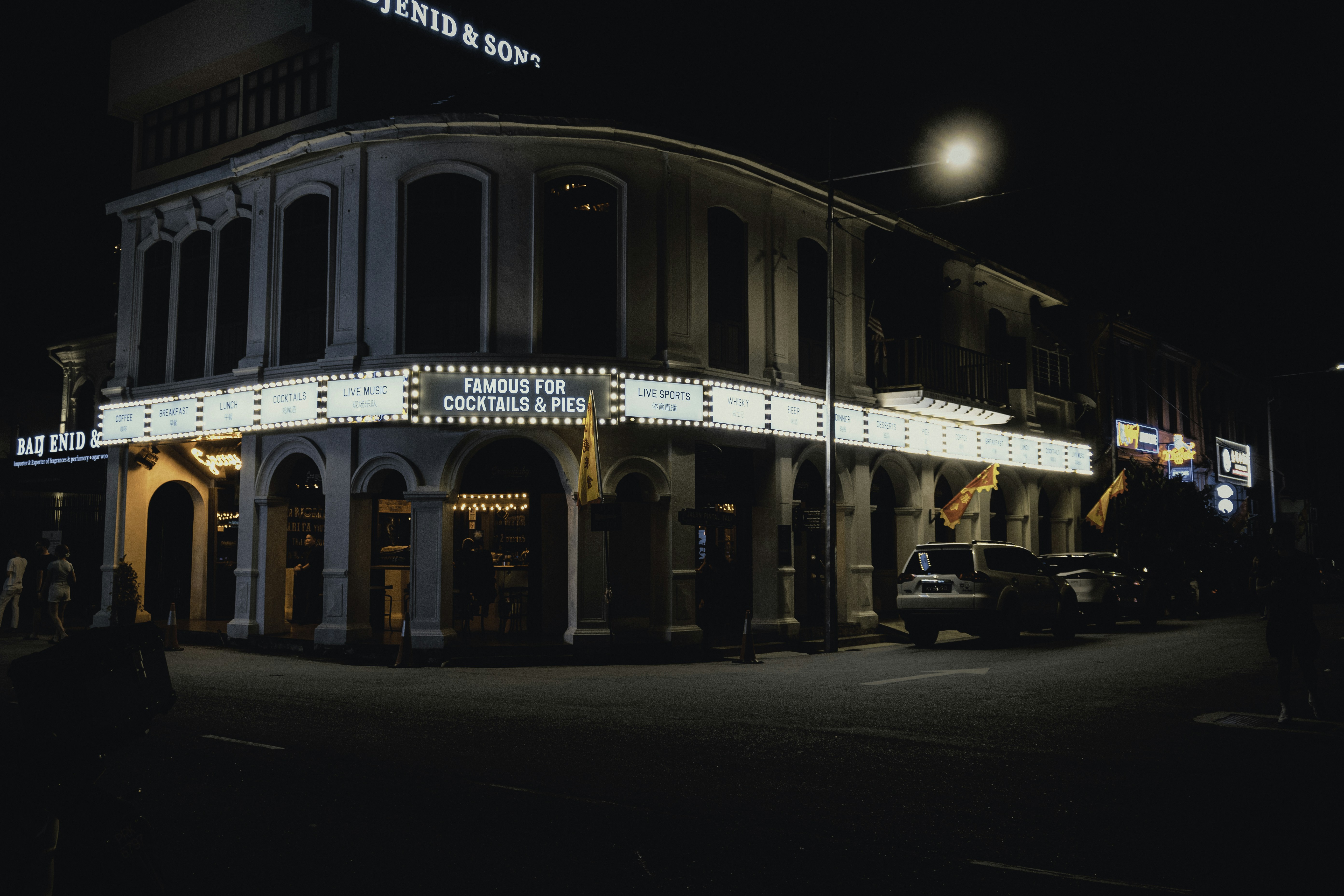 Historic building adorned with bright marquee lights showcasing its offerings, set against a night backdrop.