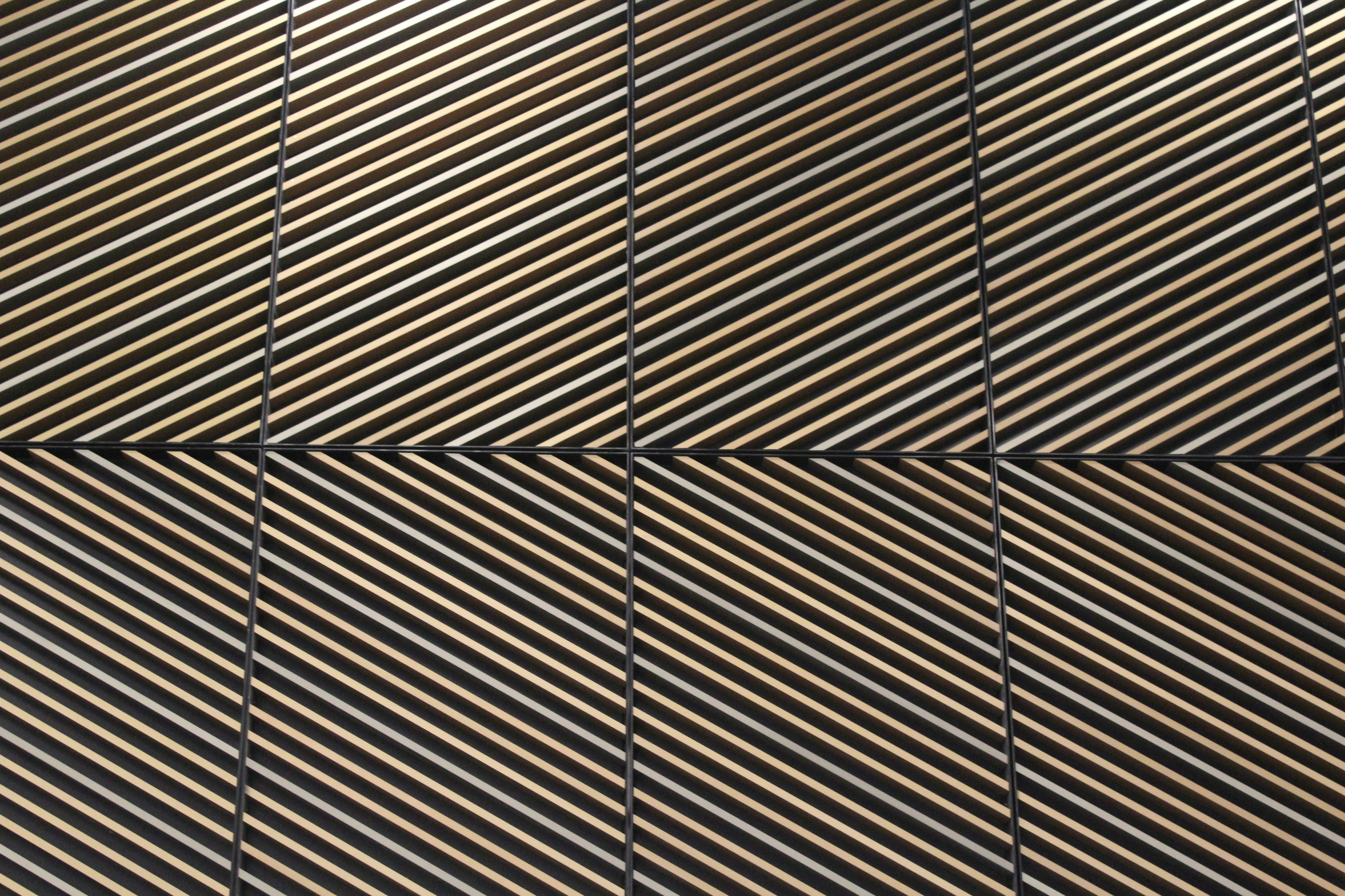 Geometric pattern of alternating black and gold diagonal stripes creating a visually striking surface design.