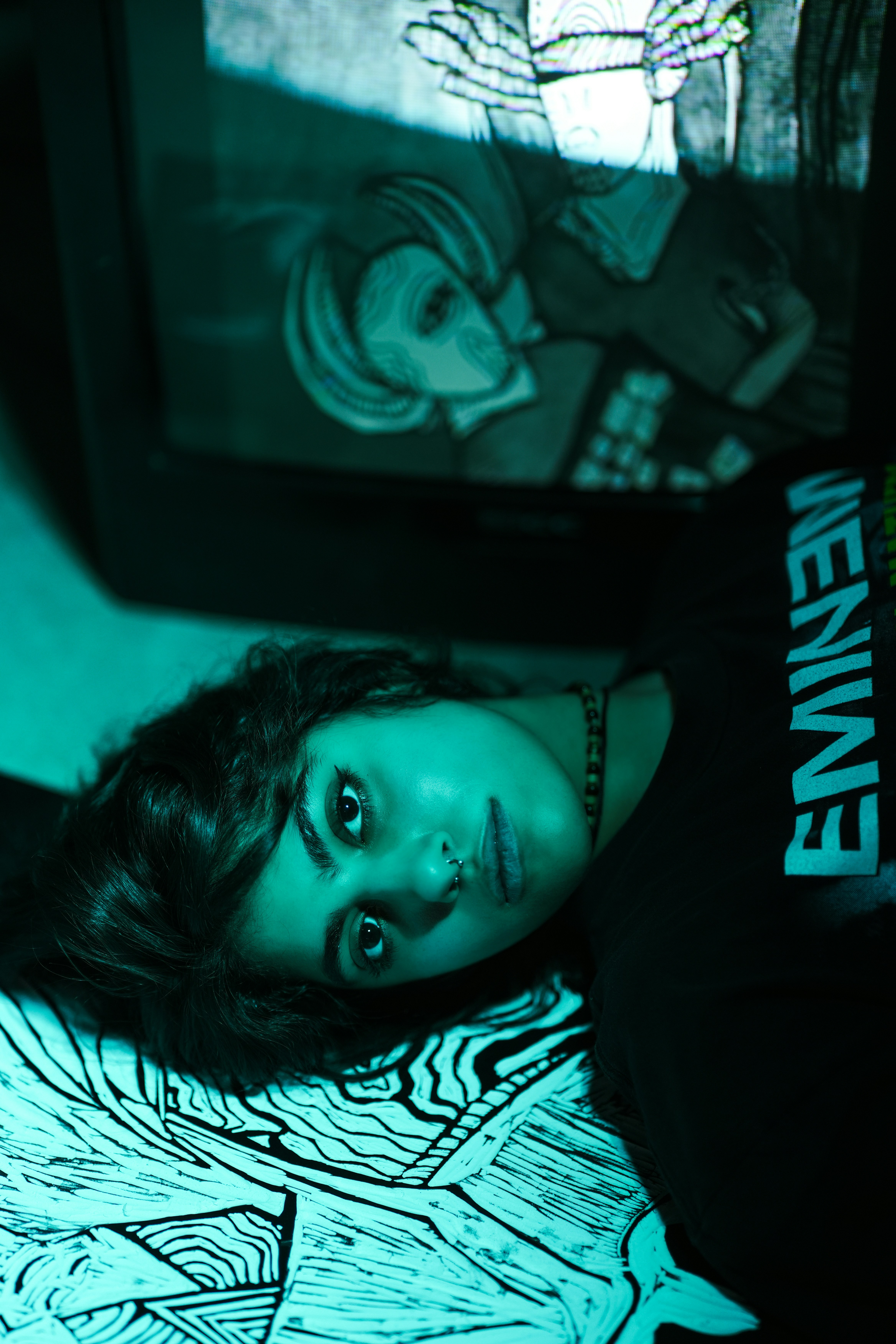 Person lying down with projection on wall.