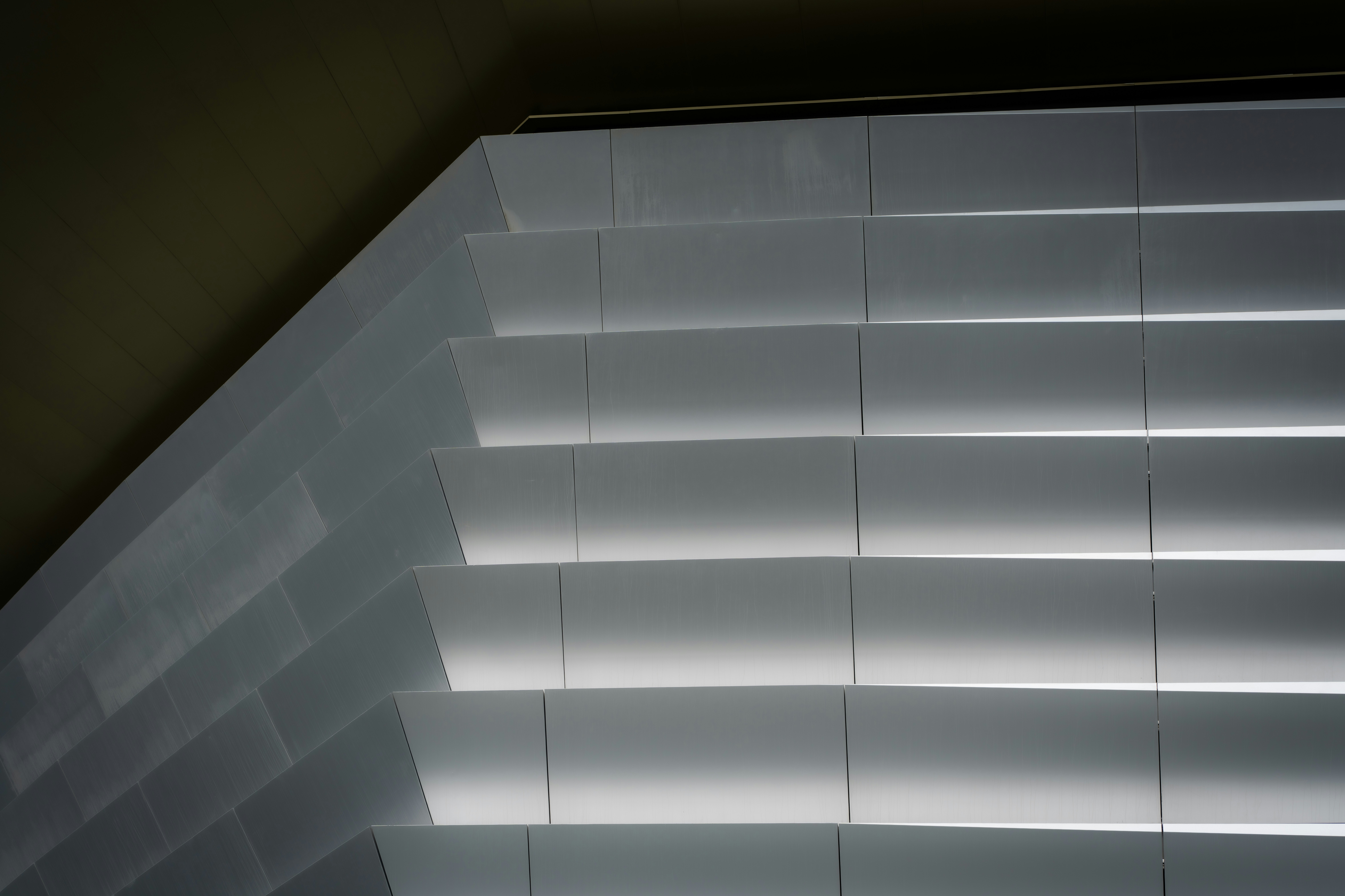 Abstract architectural detail showcasing layered panels with soft illumination creating a dynamic interplay of light and shadow.