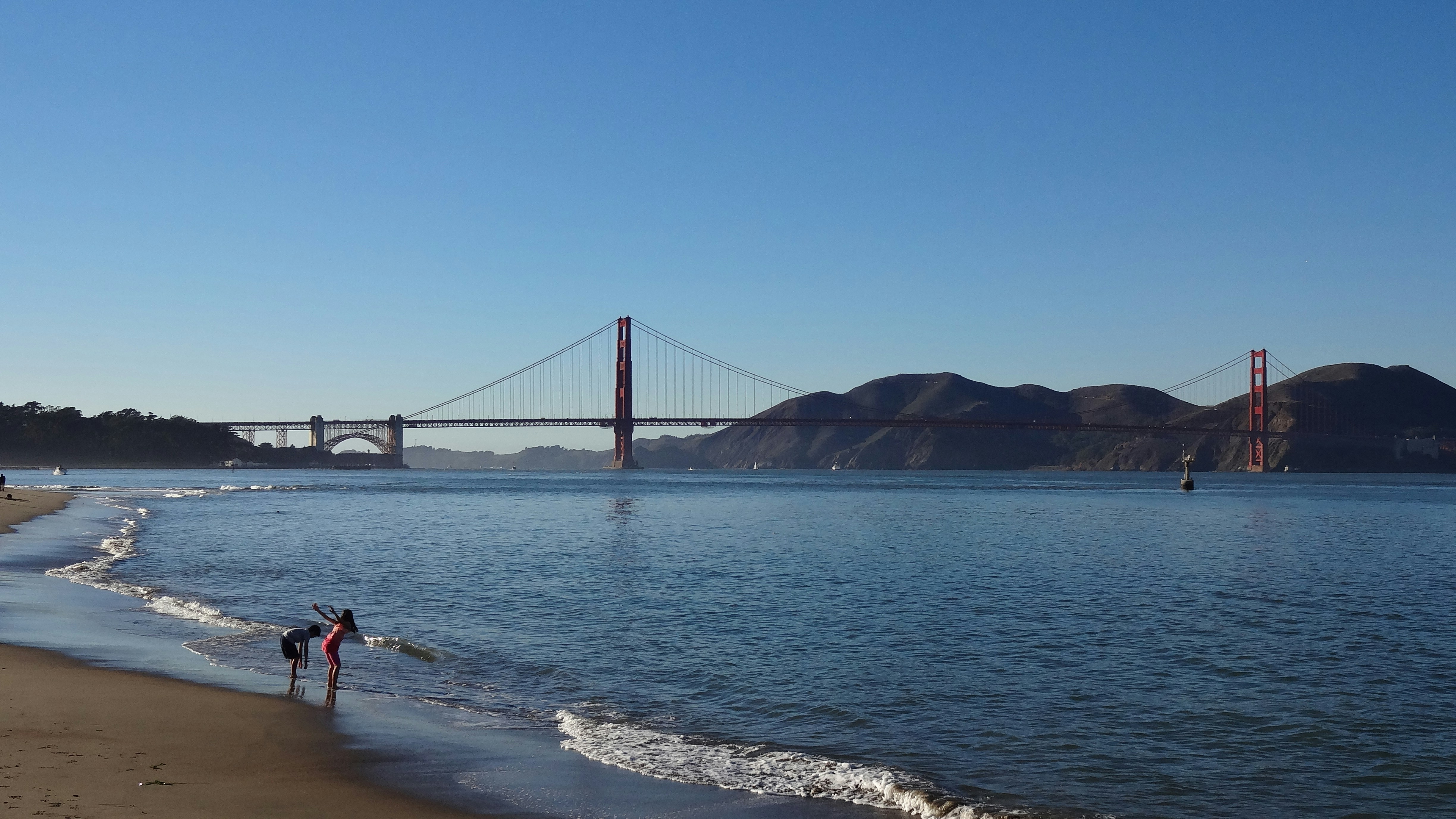 Golden gate bridge with people on the beach.
