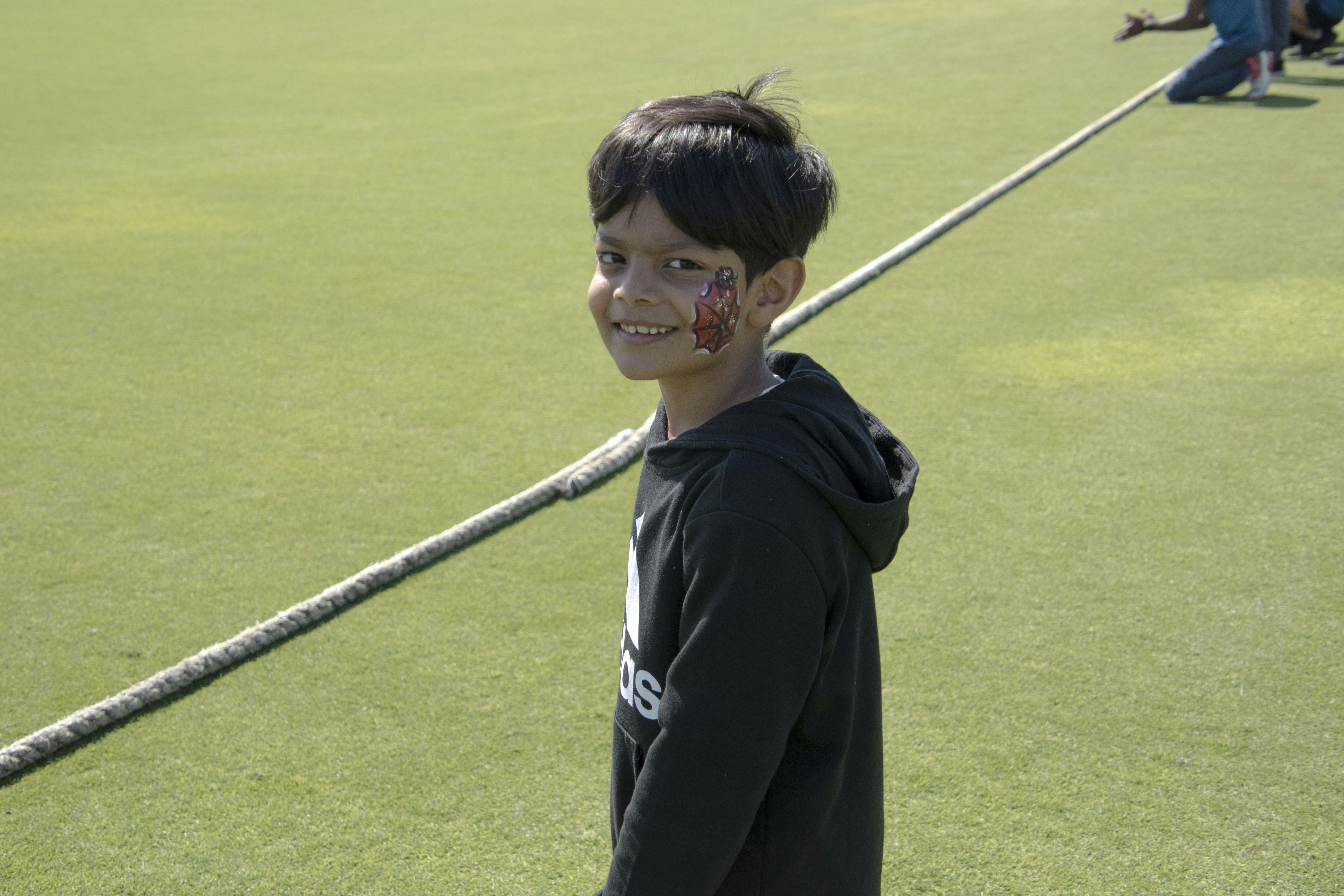 Young boy with face paint smiling outdoors