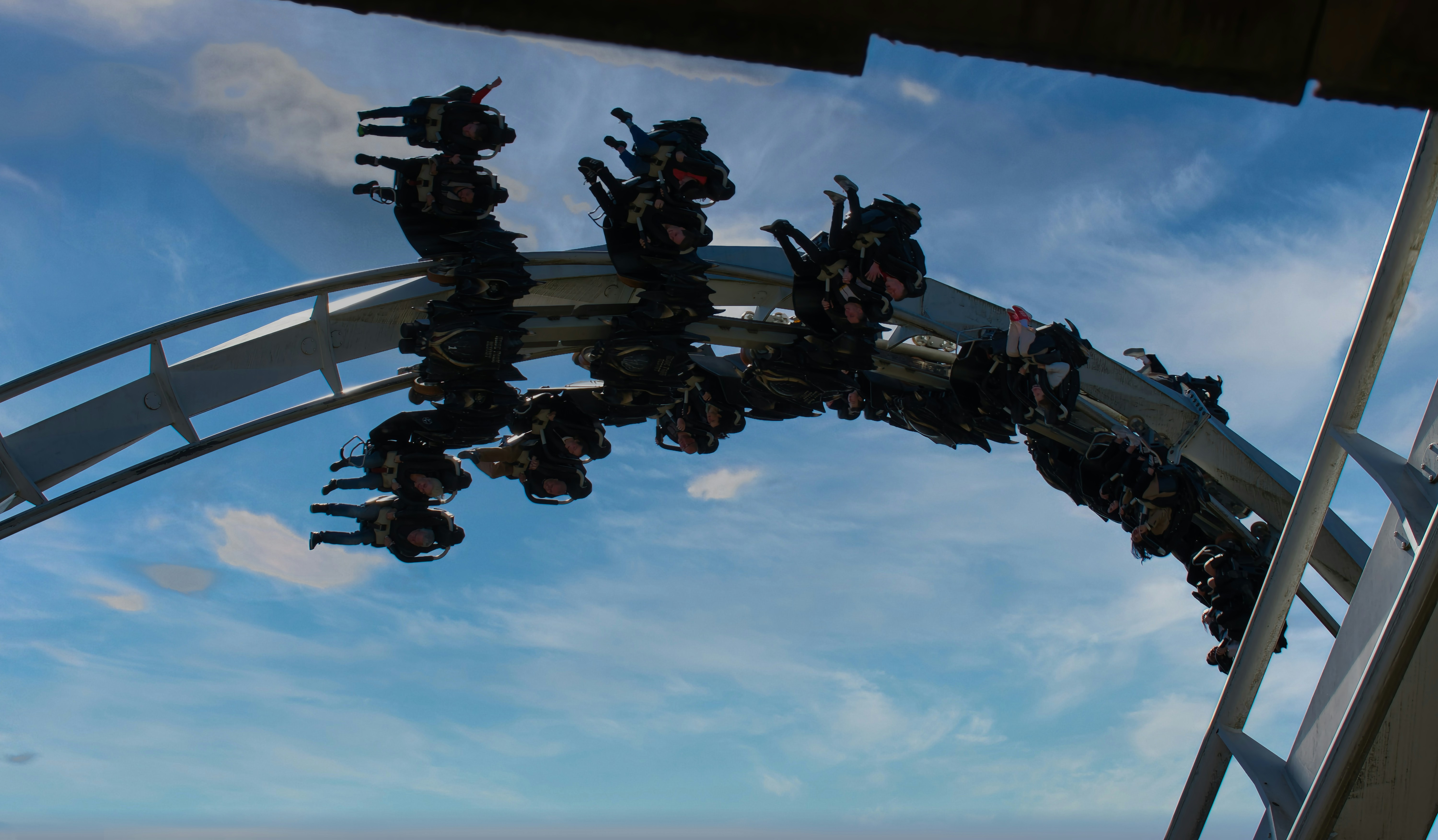 Arc of Momentum: Riders Navigate a Steel Loop Under a Bright Sky