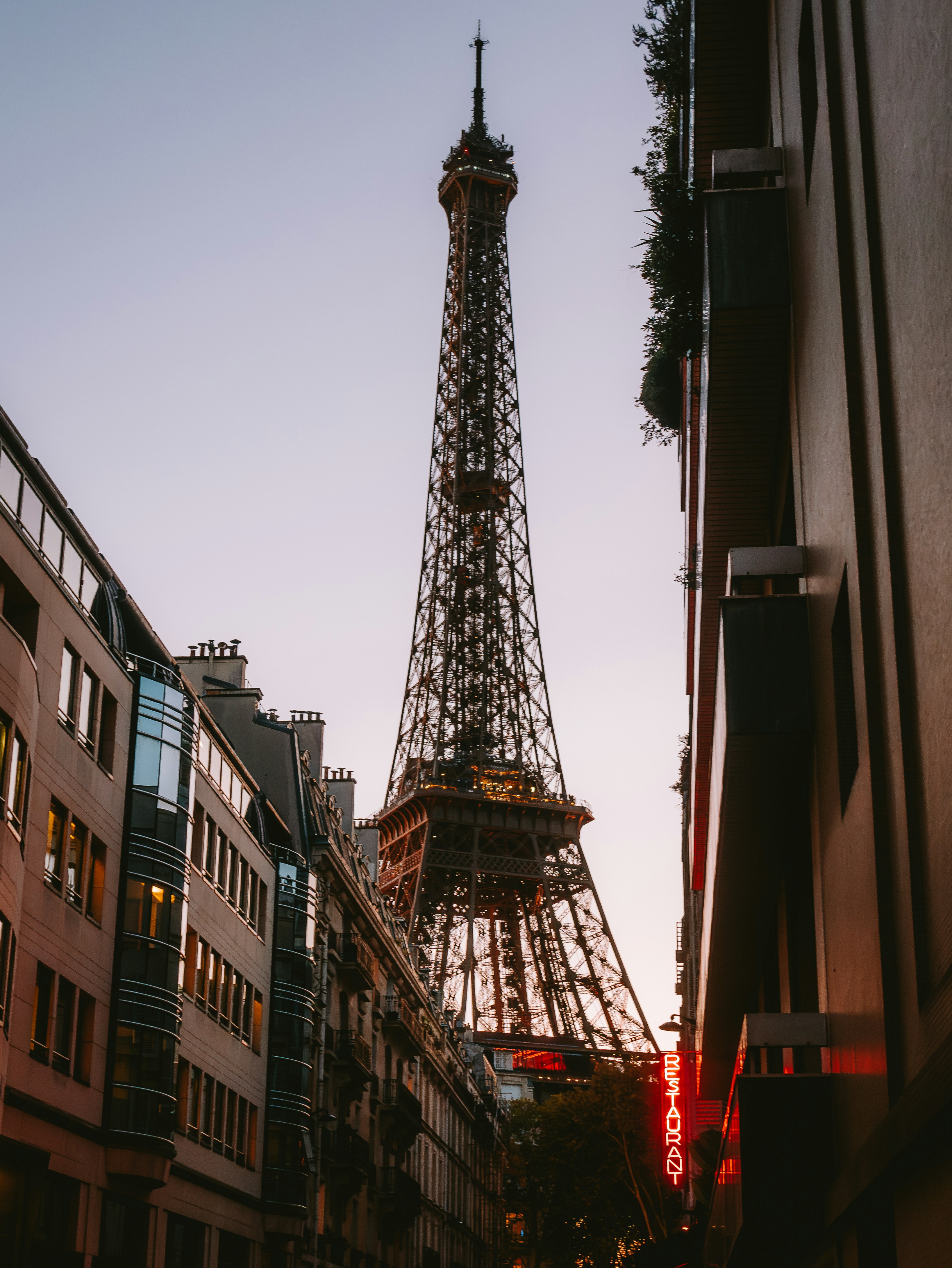 Eiffel tower viewed between buildings at dusk
