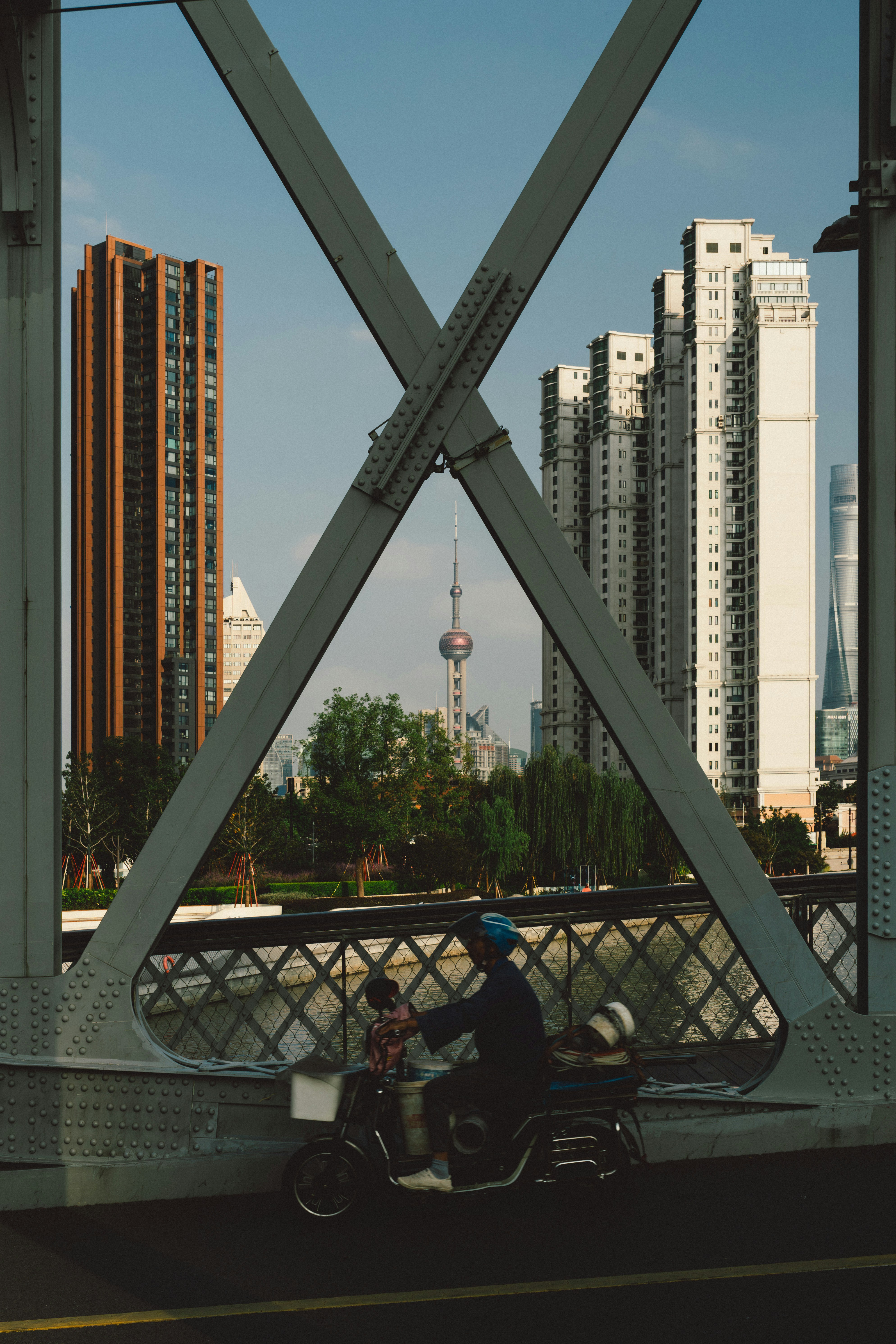 X-Frame Crossing: Motorbike Glides Beneath a Steel City Frame