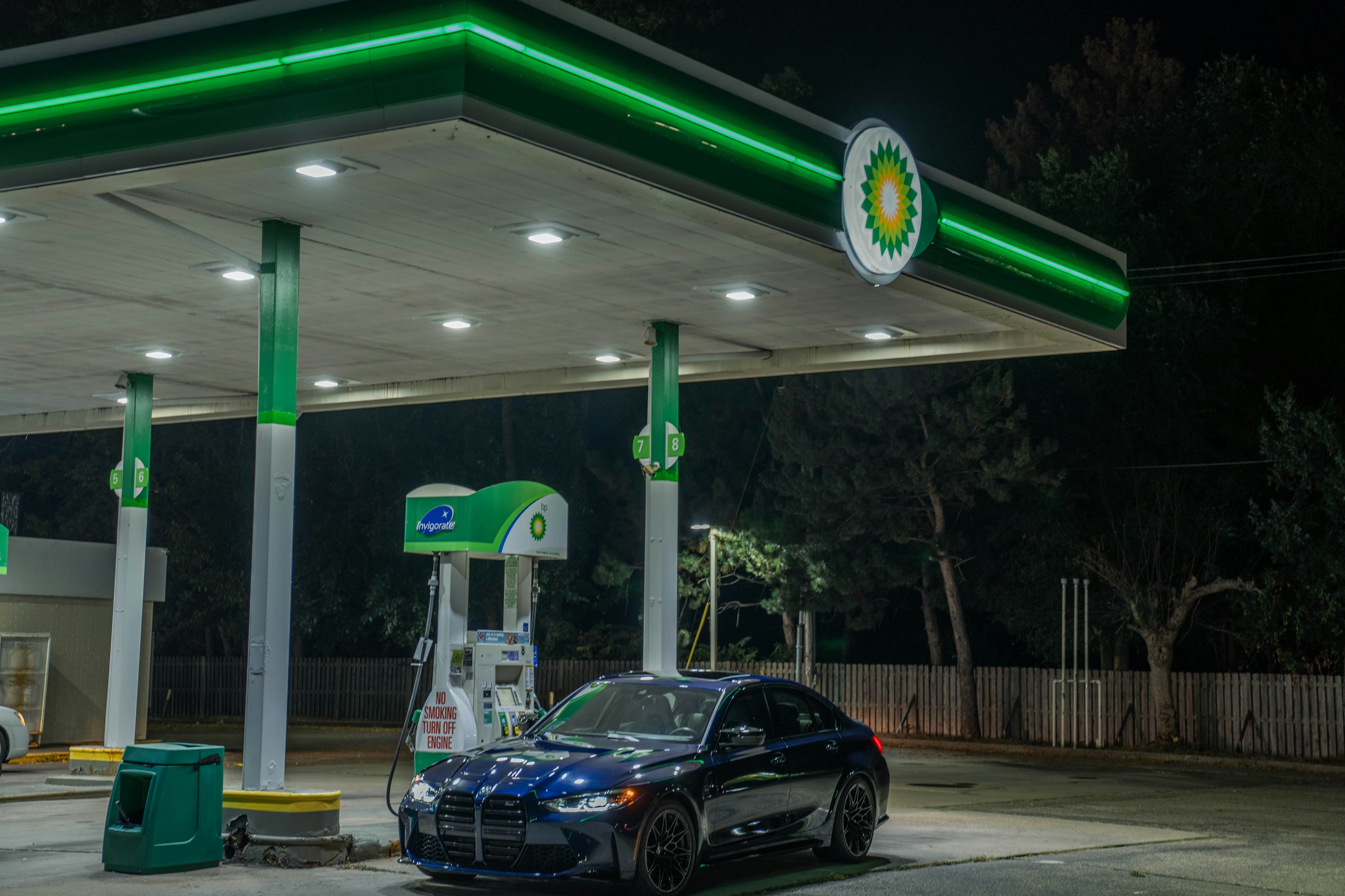 Midnight Stop Under Neon Green: A Sleek Sedan at a Quiet BP Station