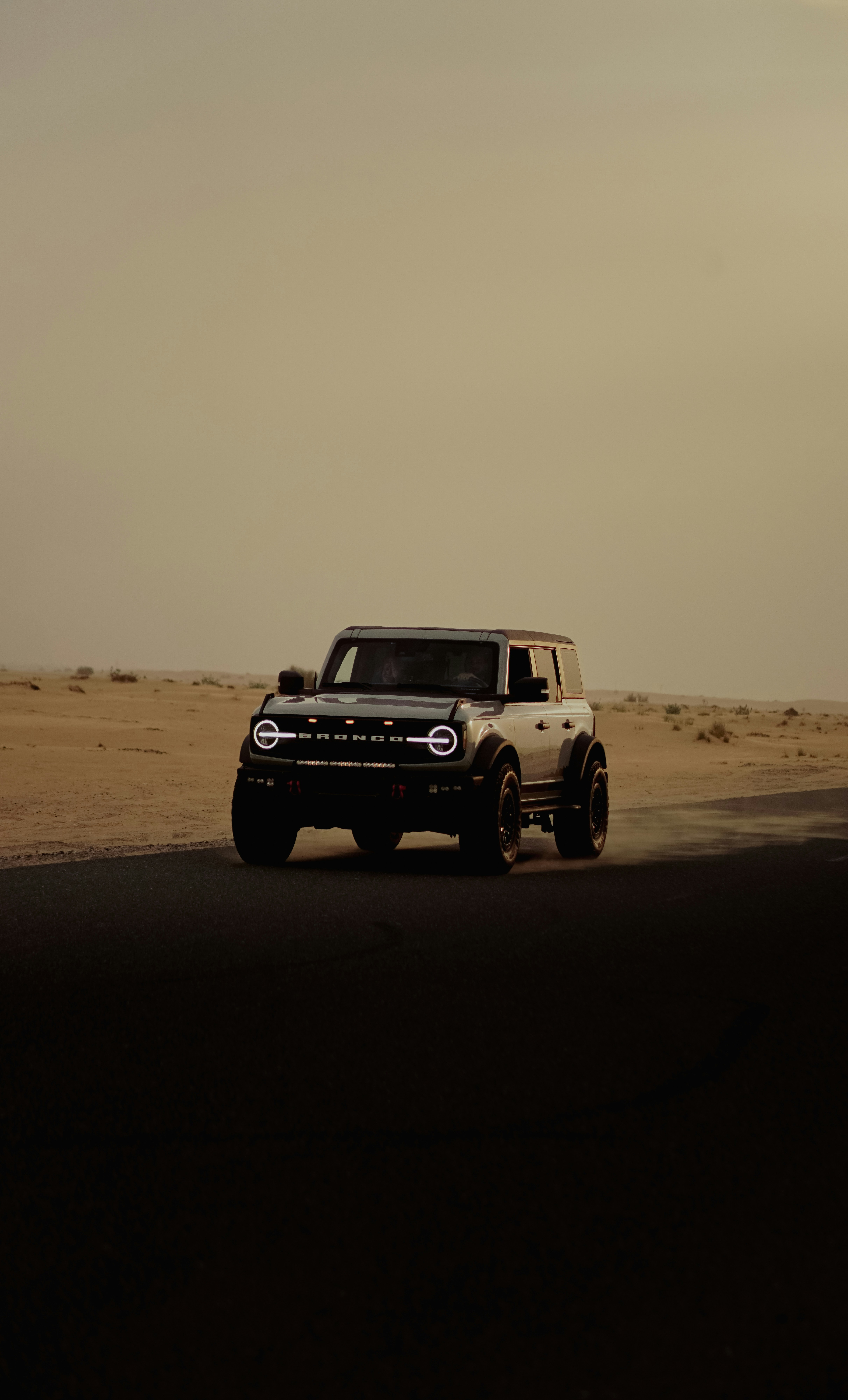 Black suv driving on a desert road