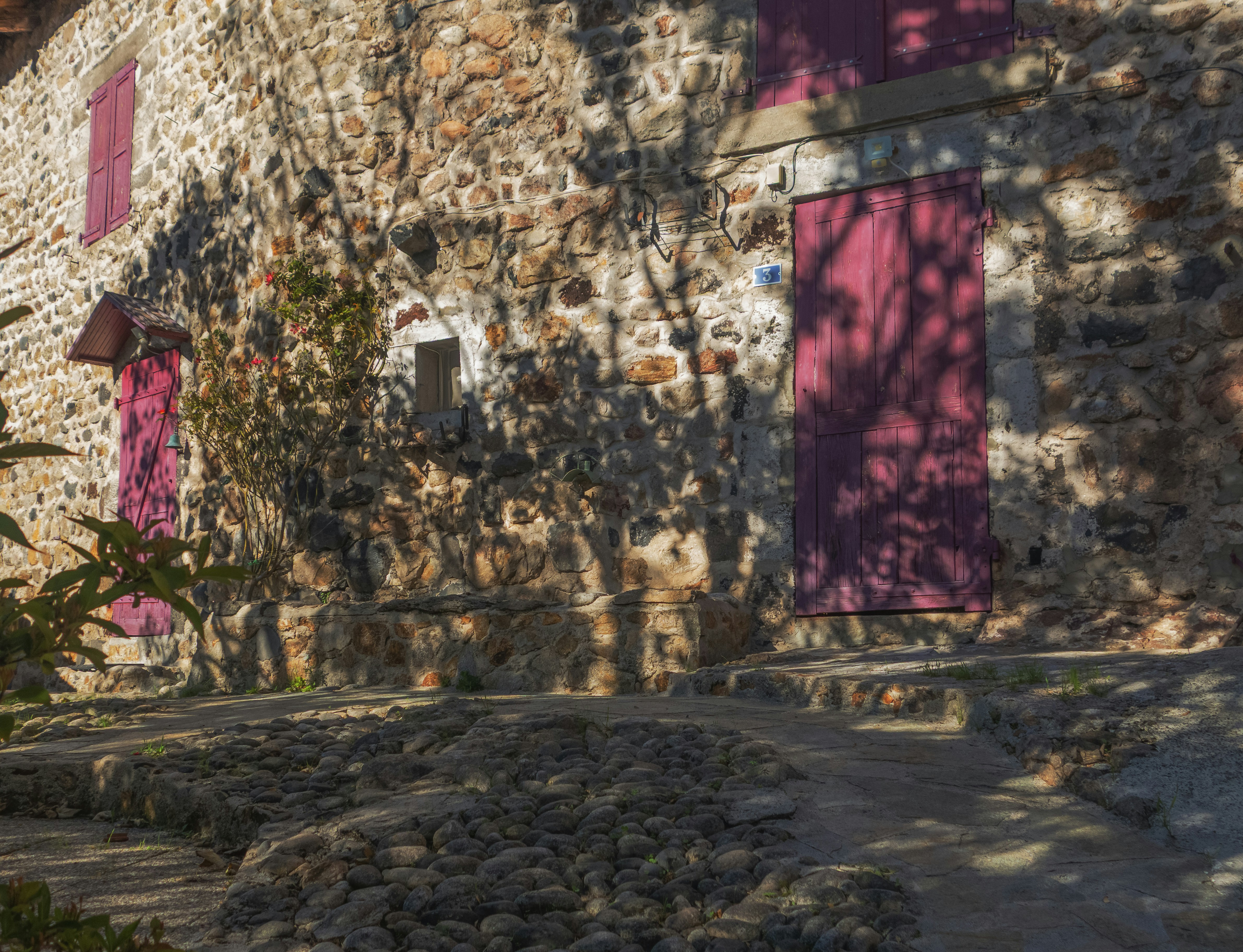 Pink Portals in a Weathered Stone Facade