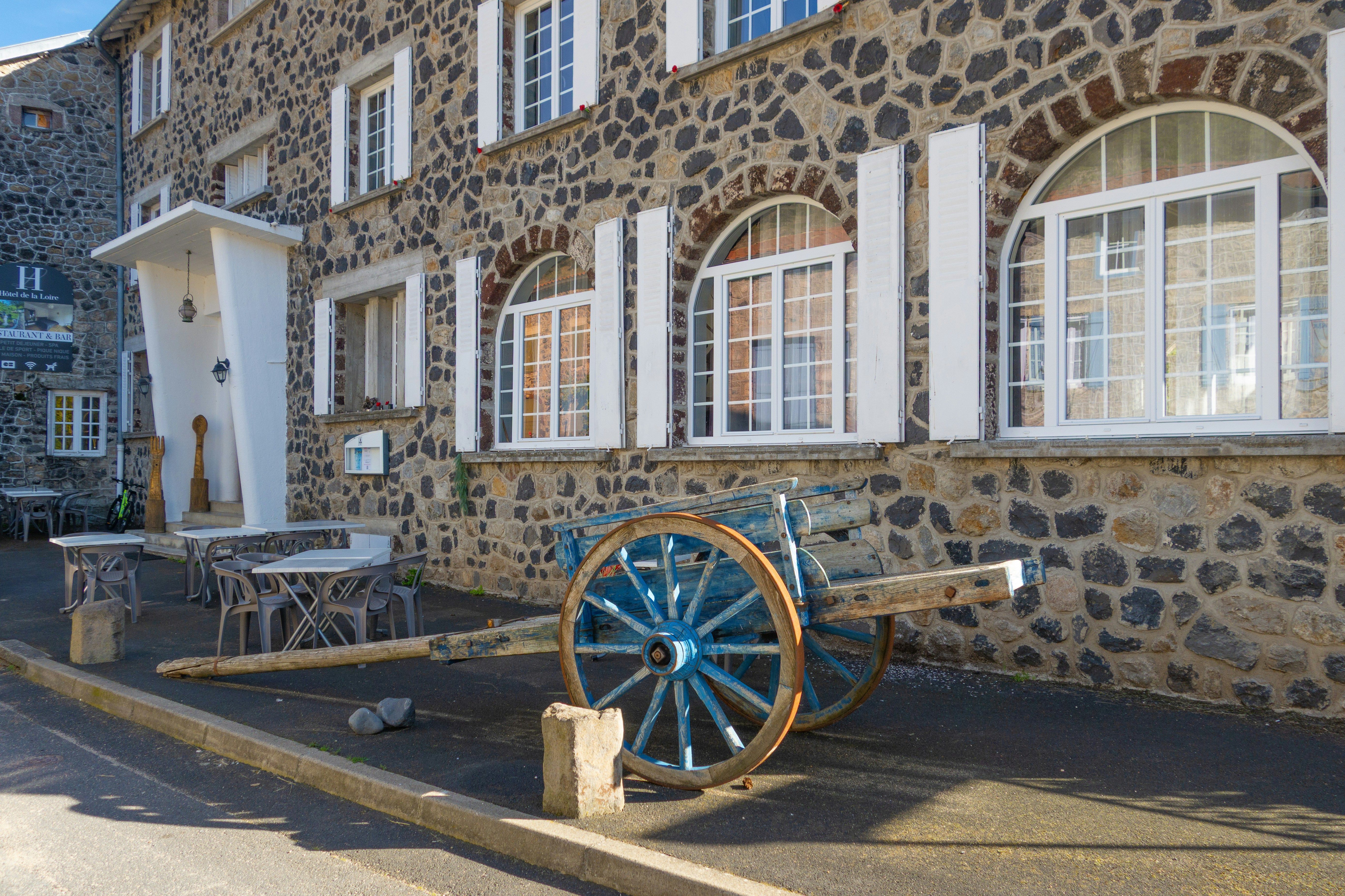 Blue-Wheel Sentinel: A Vintage Cannon Framed by a Stone Facade
