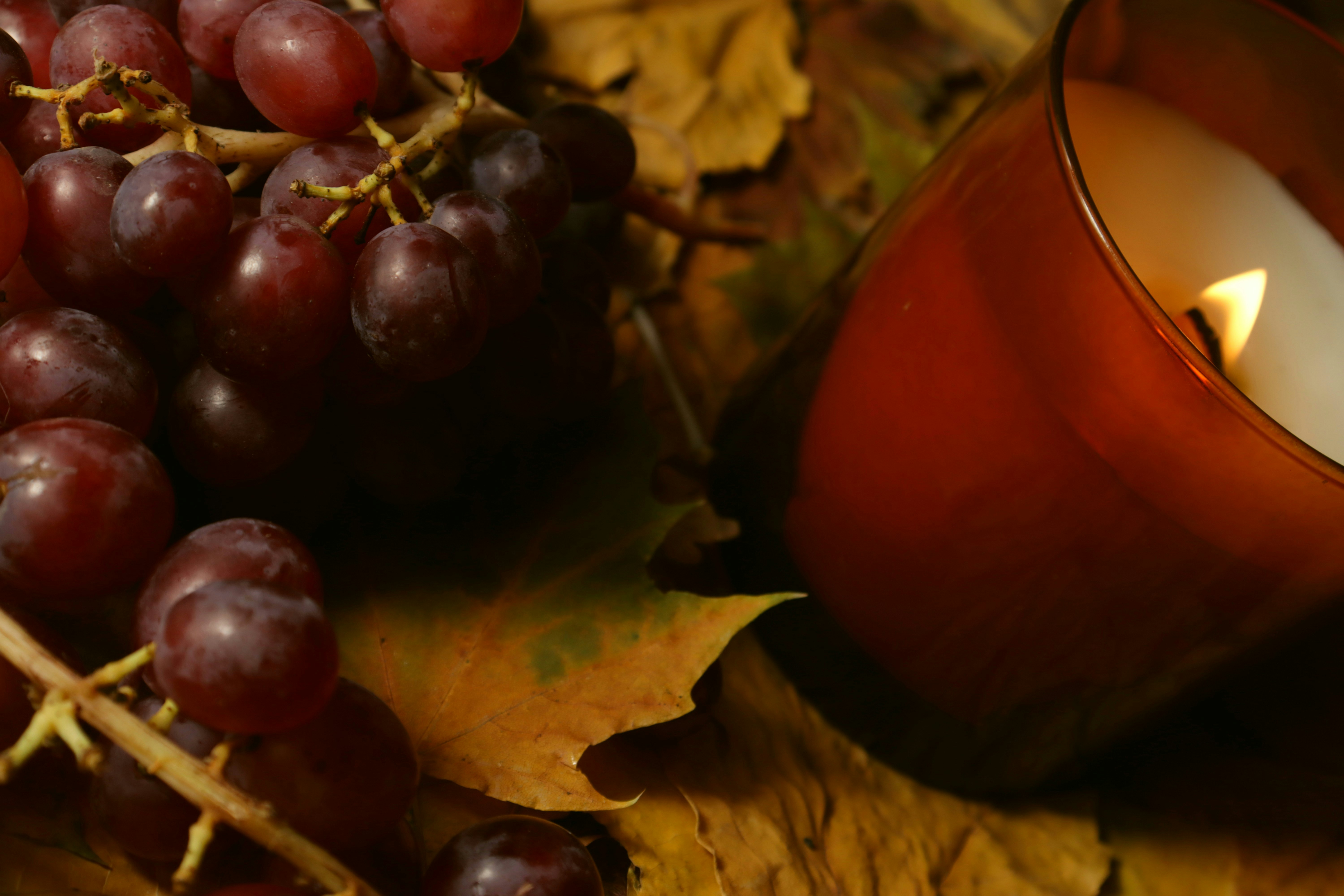 Grapes in Ember Light: Autumn Leaves Framing a Candle