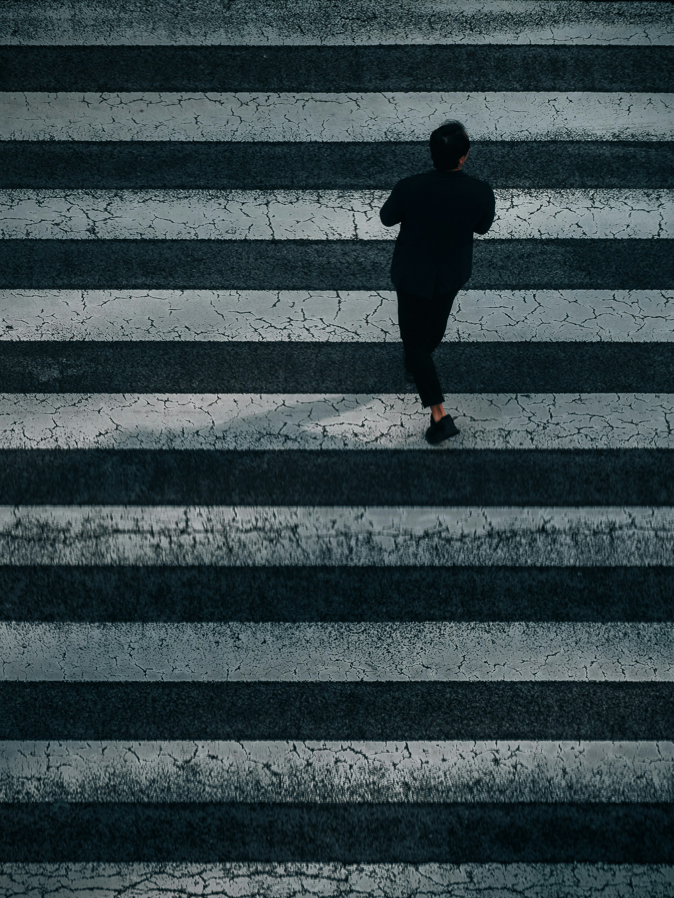 Check out my instagram - @sebastiandugudae | Person walking across a striped crosswalk.