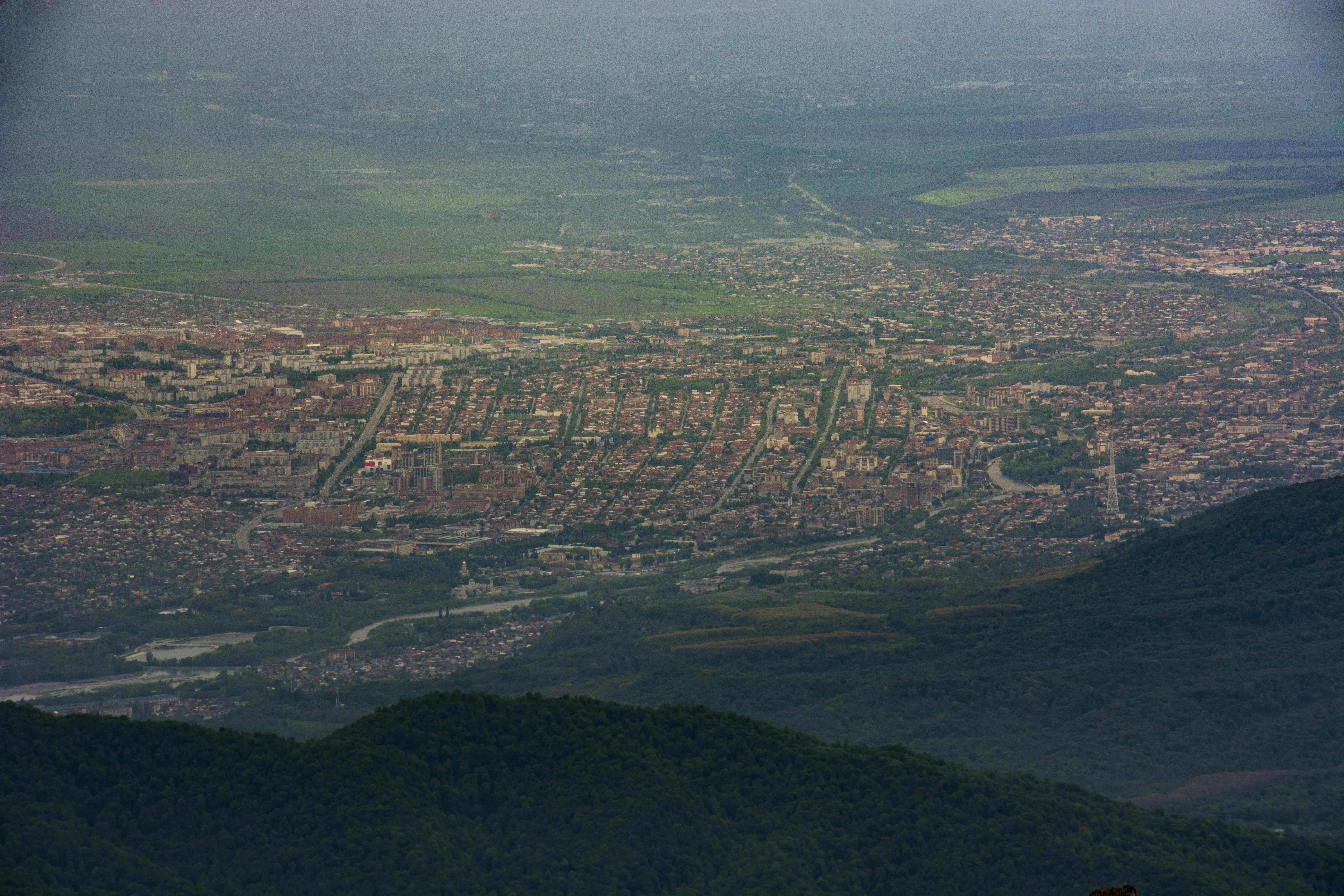 Aerial view of a sprawling city nestled beside mountains.
