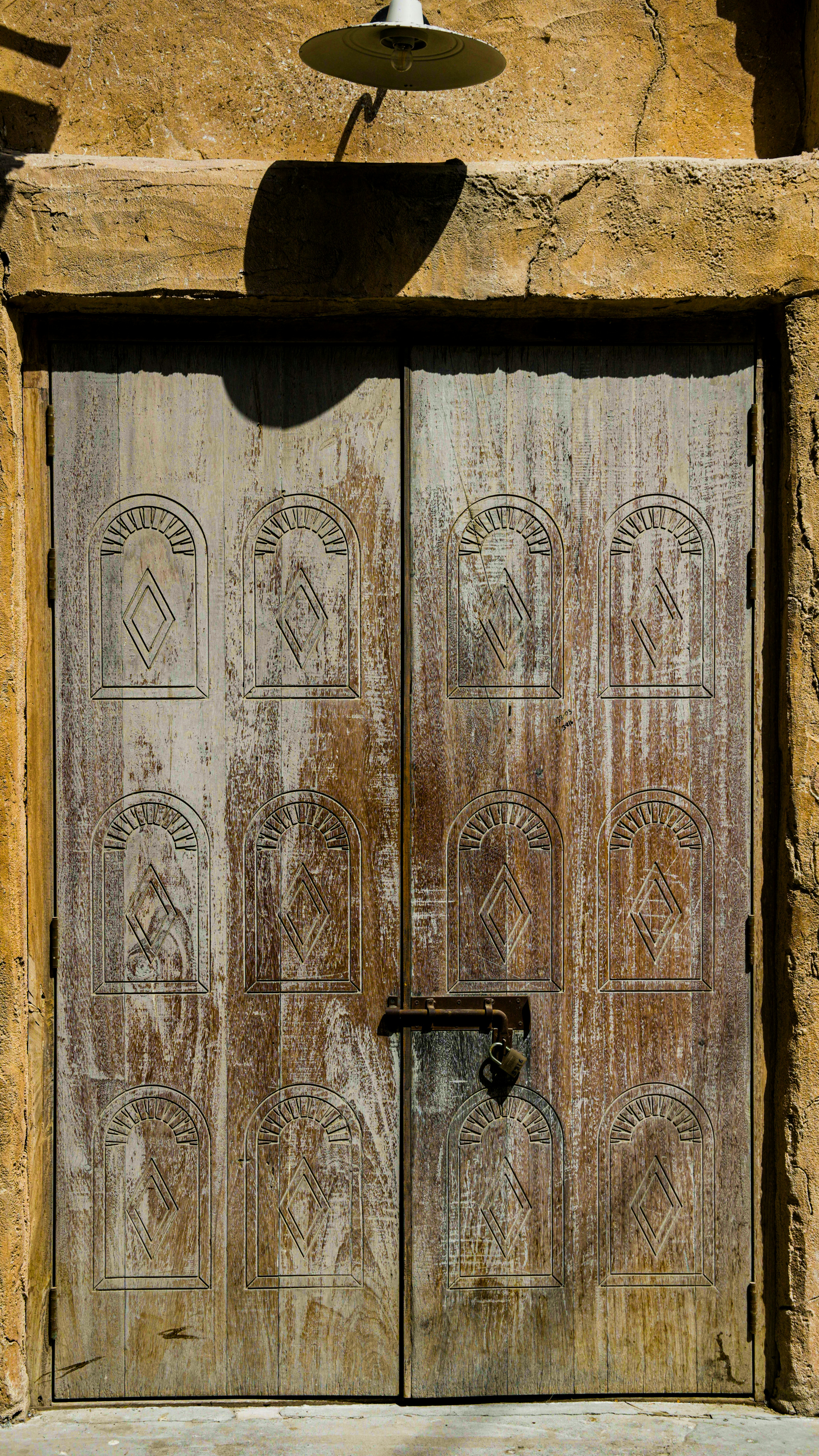 Textures, shadows, and history: an ancient door in an earthy tone that carries the mystery and simple beauty of traditional Middle Eastern architecture.