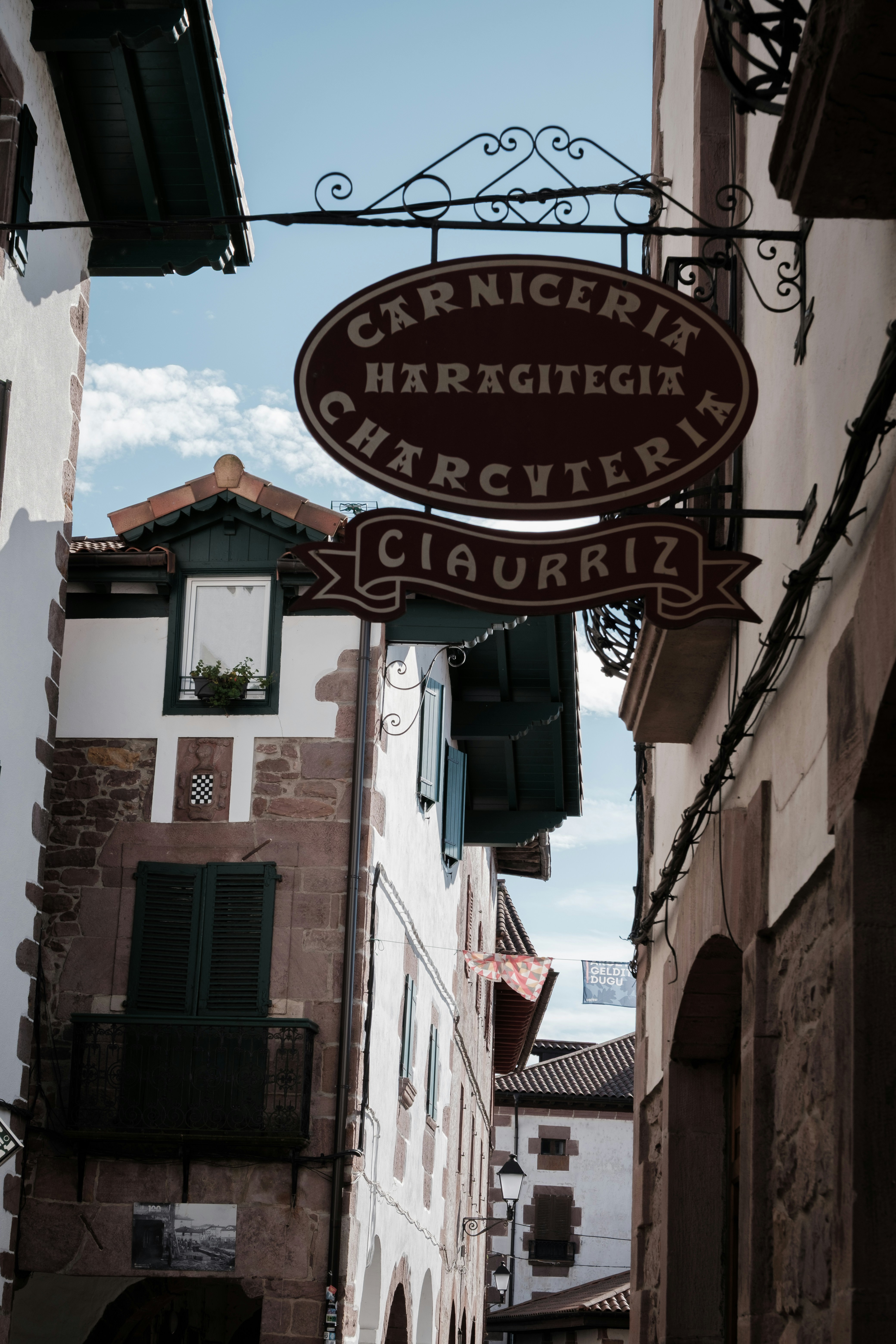 Charming sign for a local butcher shop nestled between traditional buildings in a quaint street. The inviting atmosphere reflects the essence of local culture.