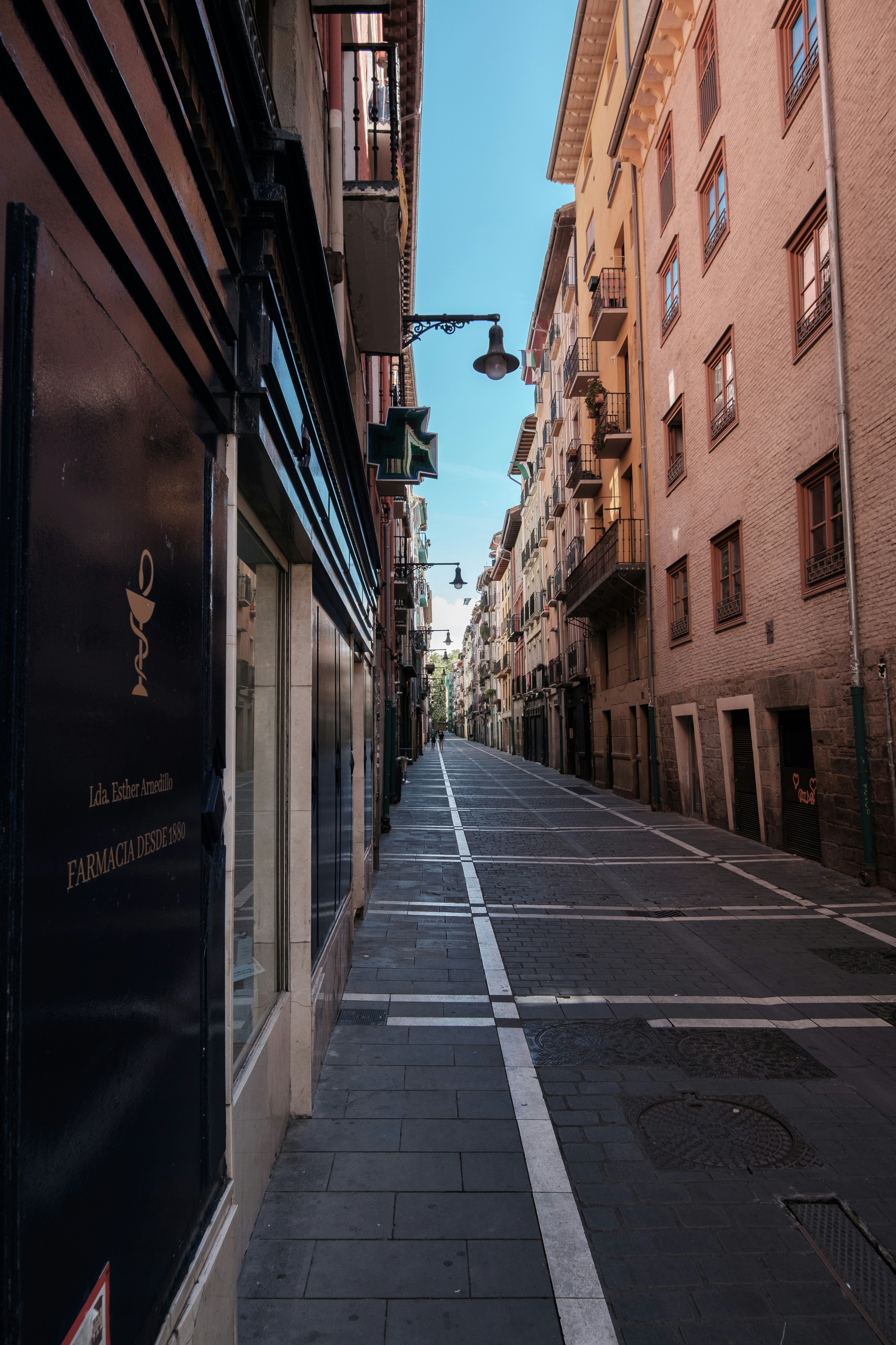 Roaming around Pamplona Downtown | Narrow street with buildings and white lines on road