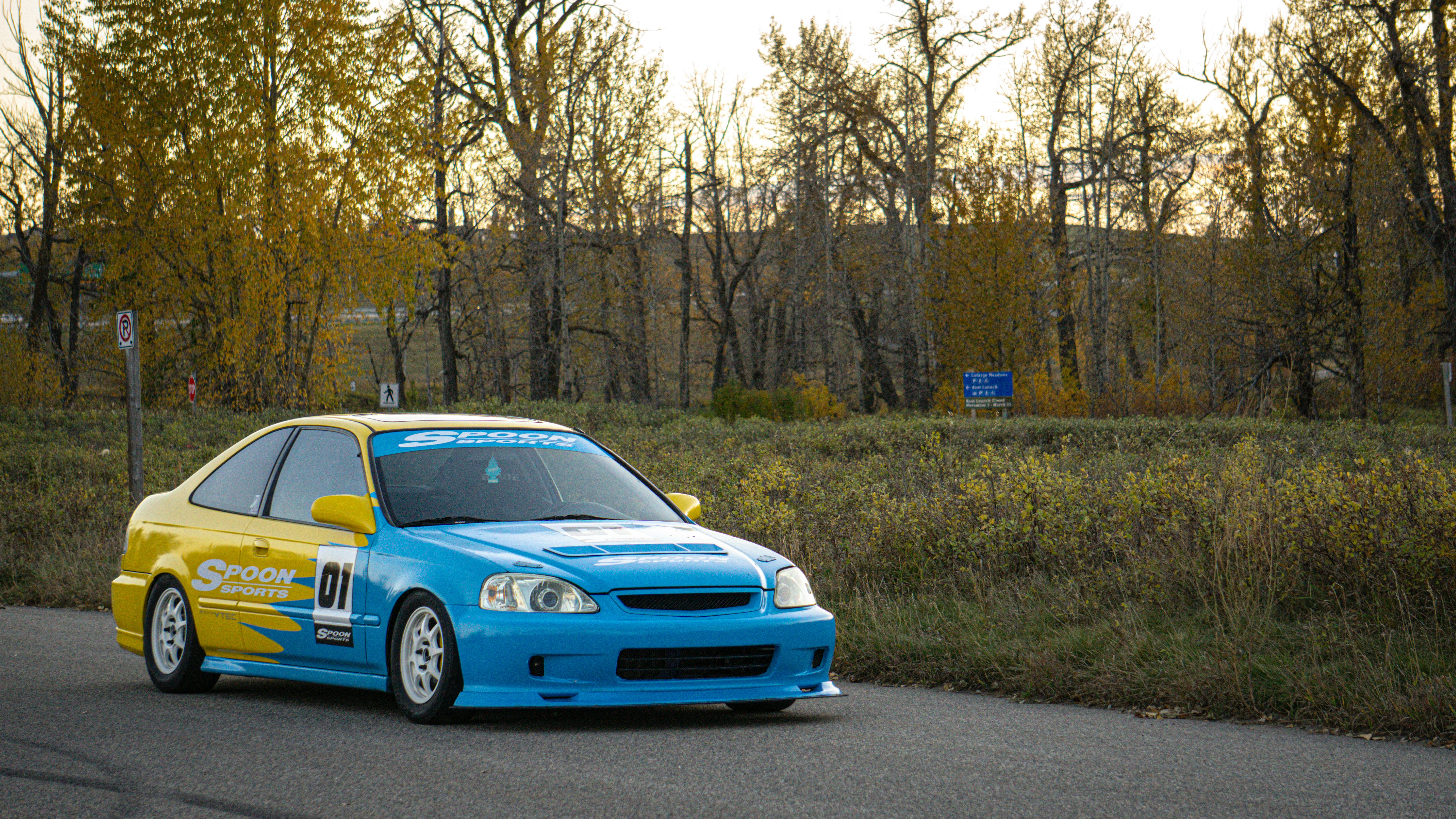 A blue and yellow race car driving on a road.
