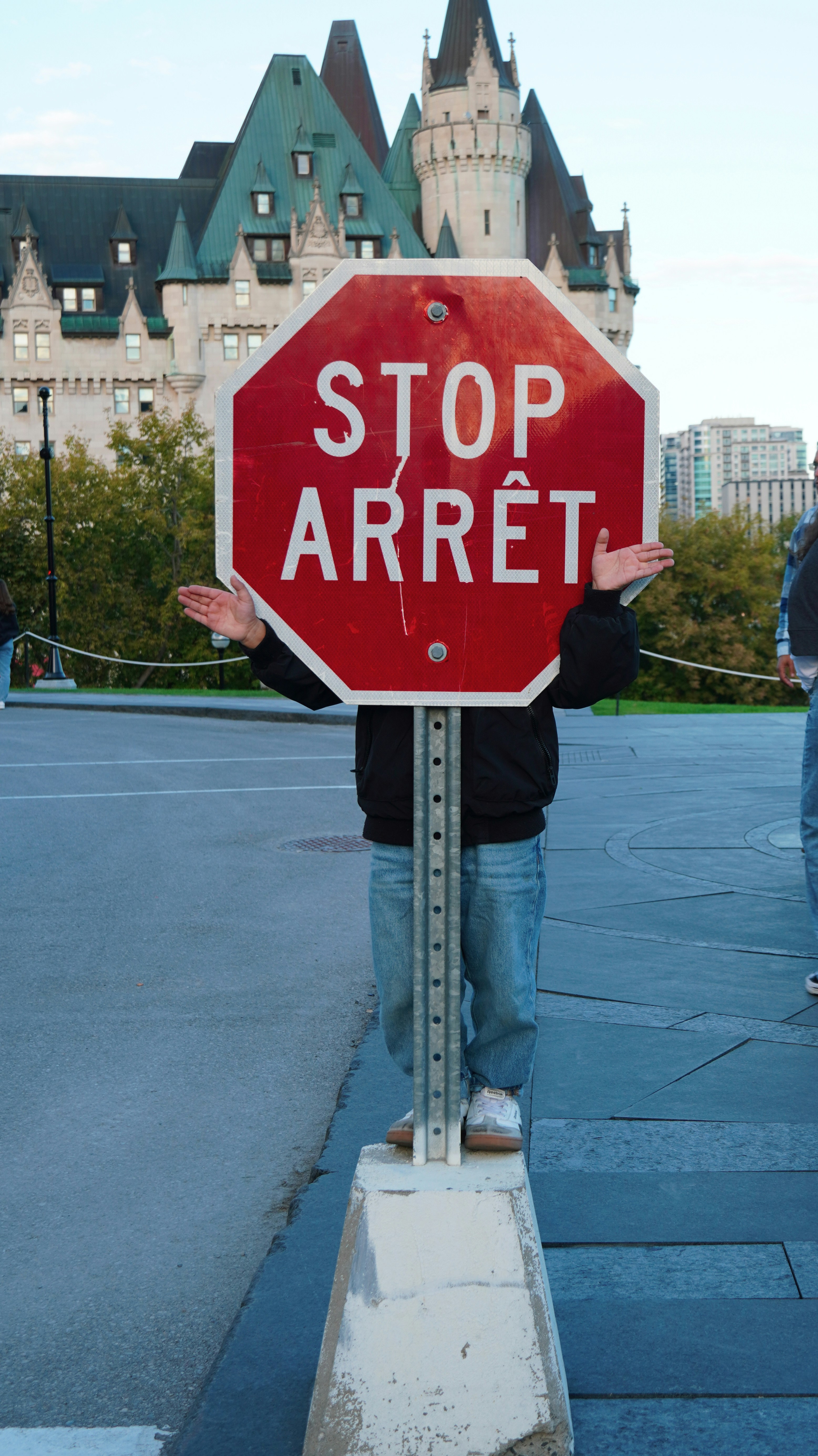 Stop sign | Person holding a stop sign in front of a building.