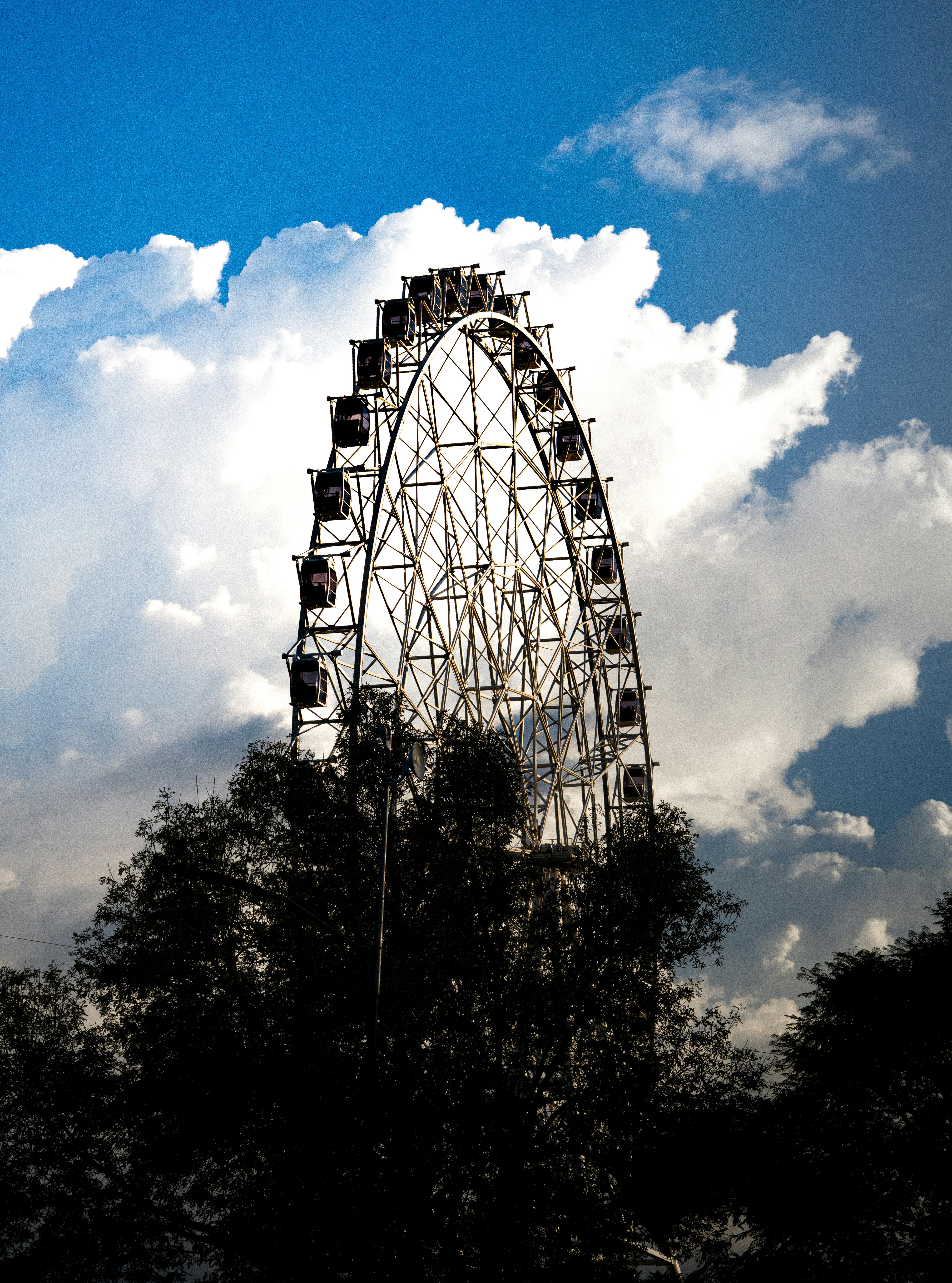 Ferris wheel against a dramatic cloudy sky.